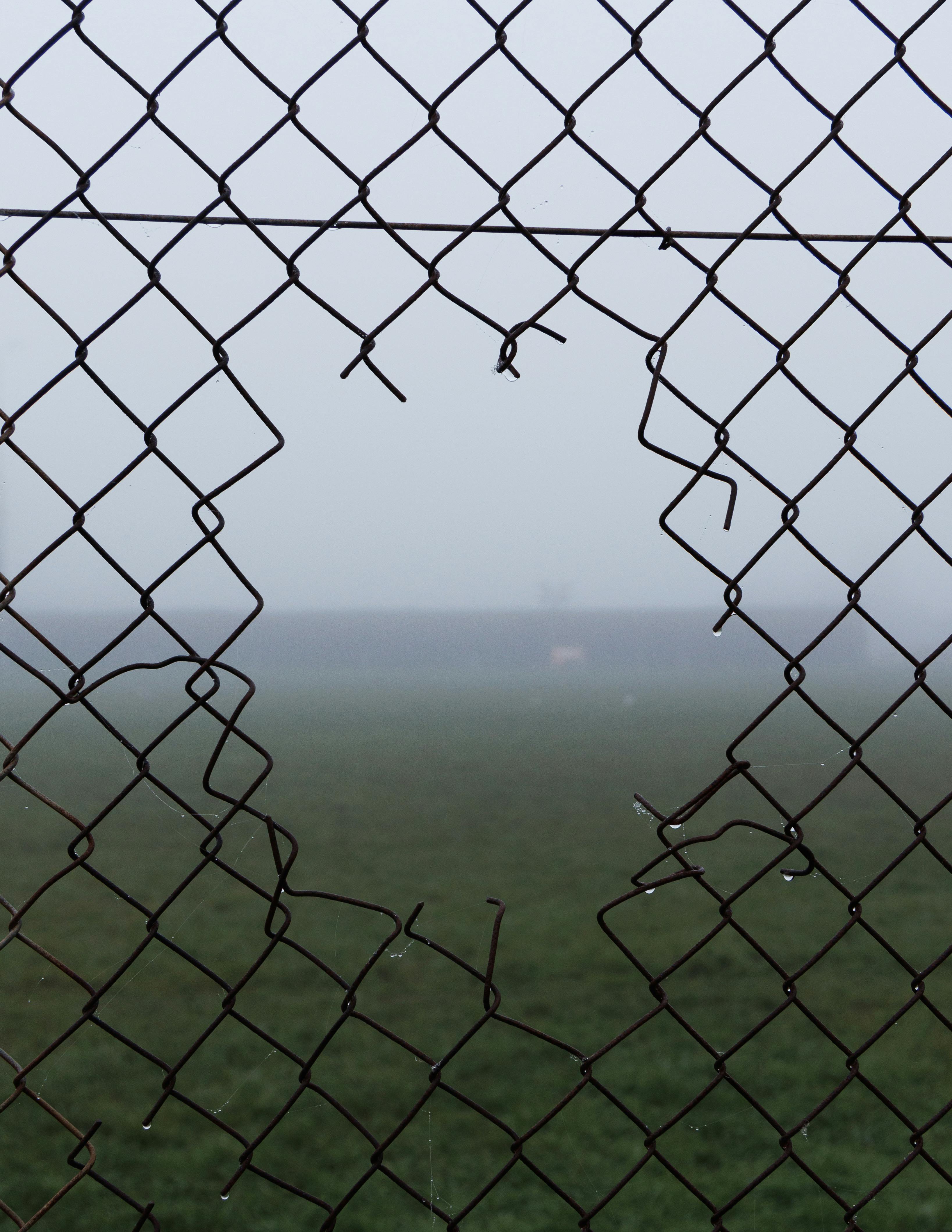 Broken Chain Link Fence on Foggy Day · Free Stock Photo