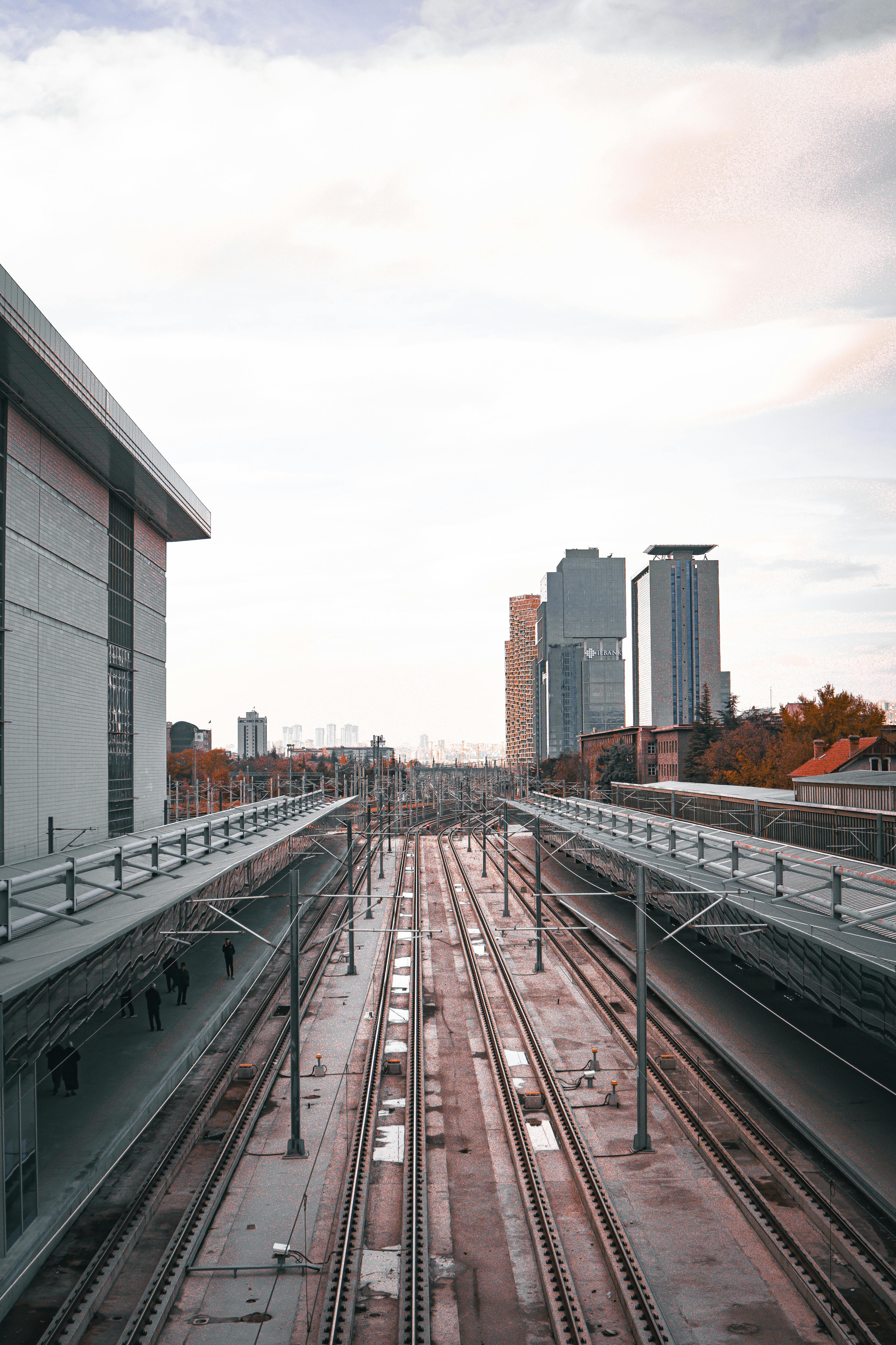 Urban Railway Tracks with City Skyline · Free Stock Photo