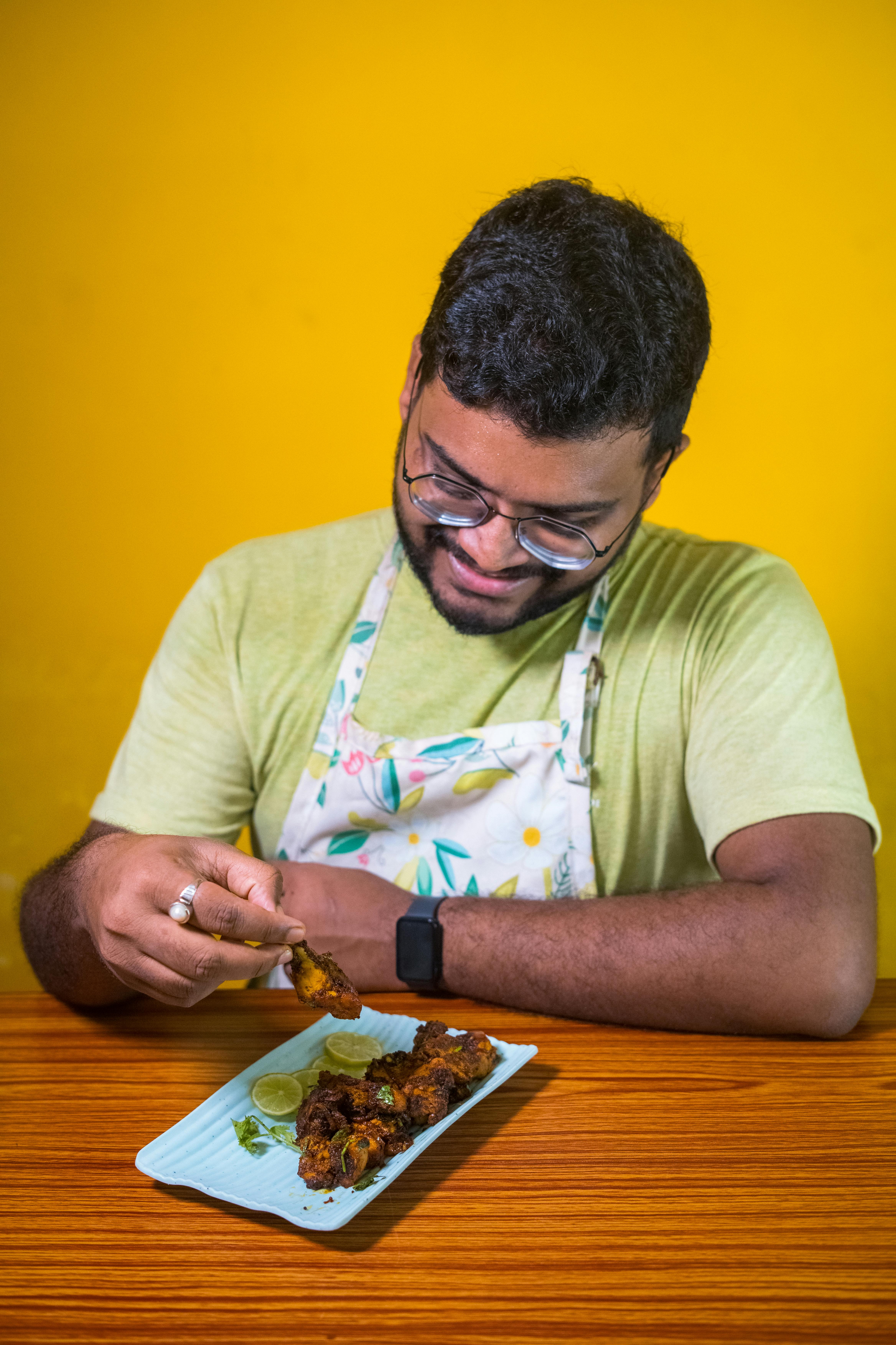 Man Enjoying Fried Chicken with Vibrant Background · Free Stock Photo