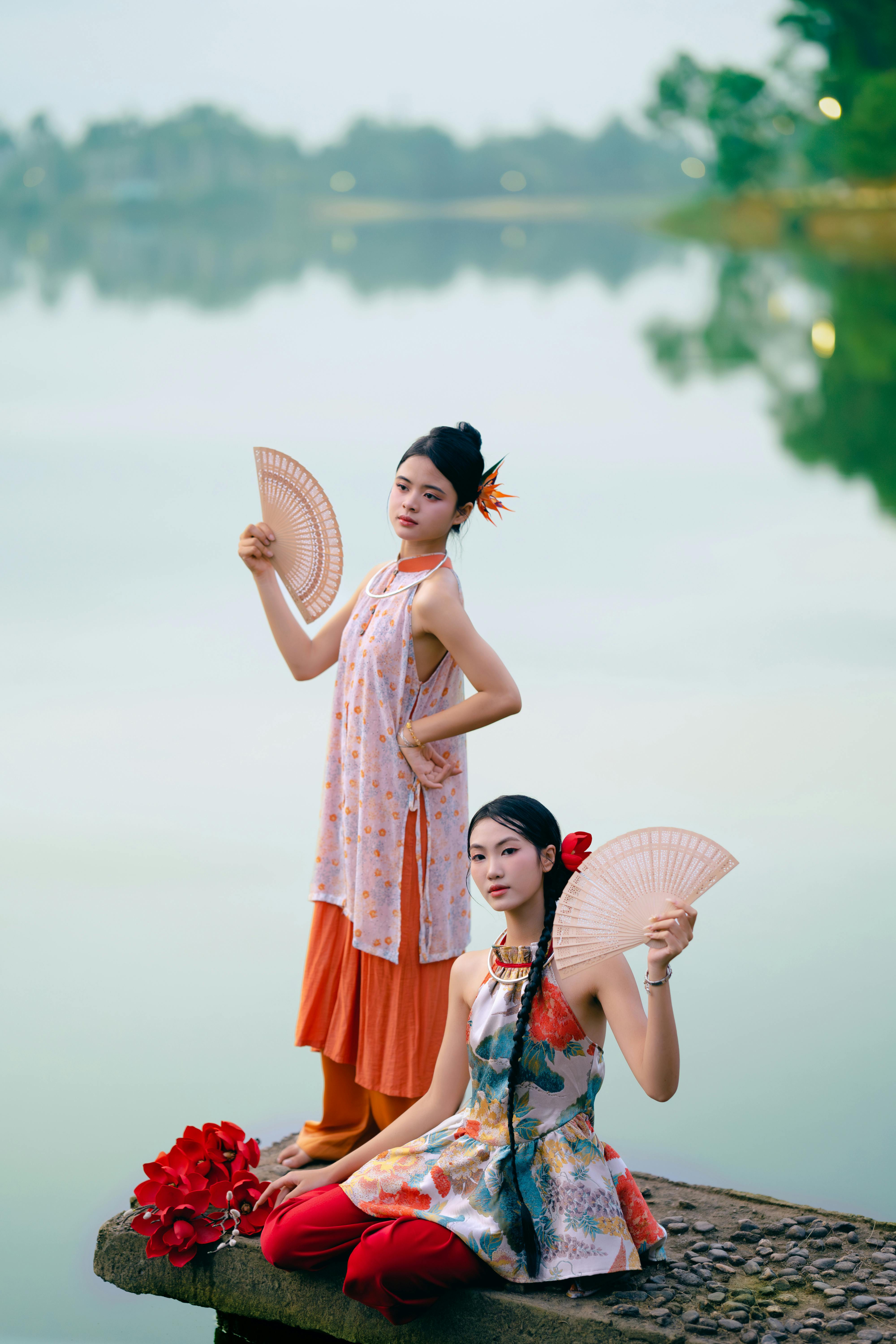 Elegant Portrait of Women with Fans by Tranquil Lake · Free Stock Photo