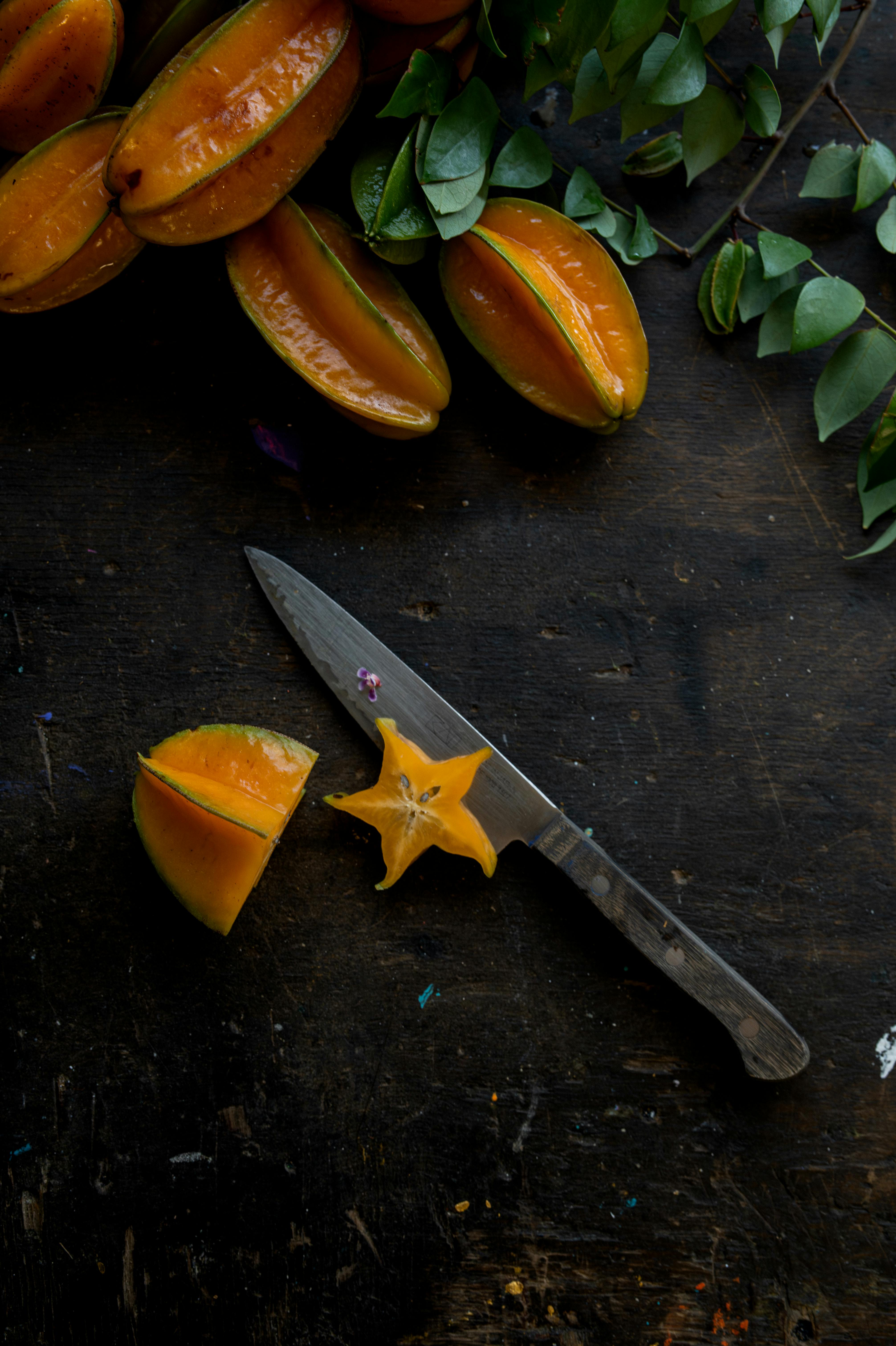 Fresh Starfruit with Knife on Rustic Table · Free Stock Photo