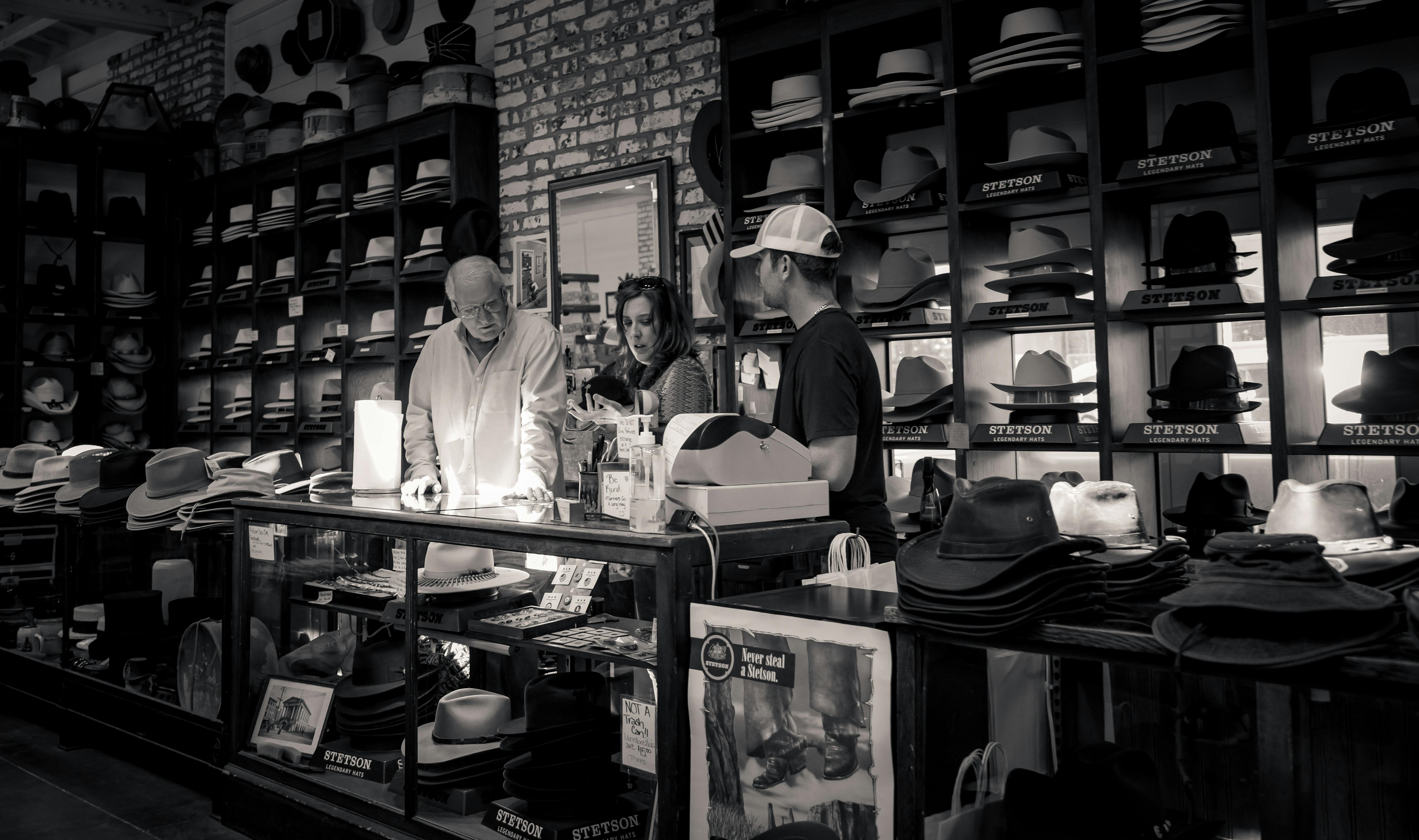 Vintage Hat Shop with Customers in Black and White · Free Stock Photo