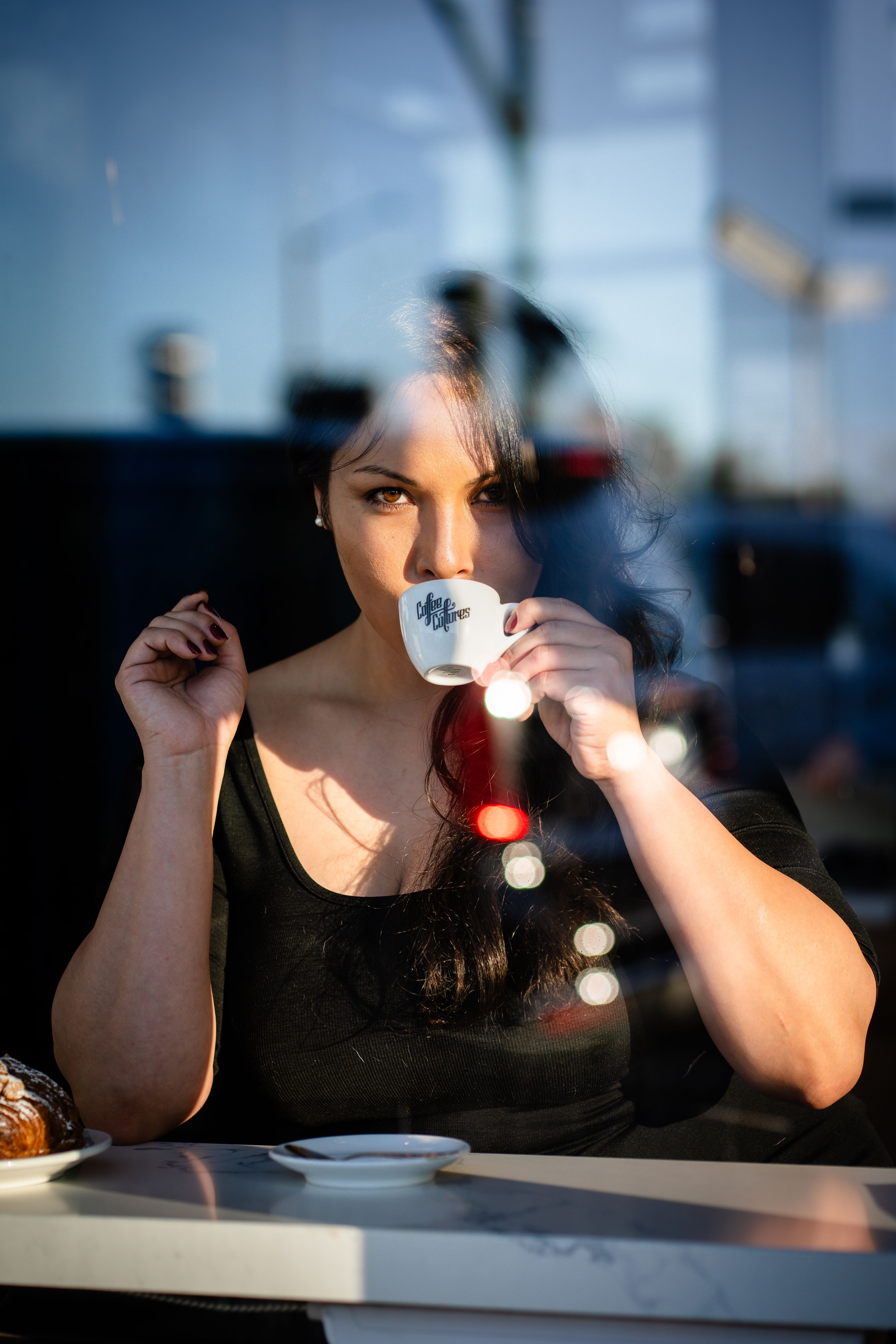 Woman Enjoying Coffee Through Cafe Window · Free Stock Photo