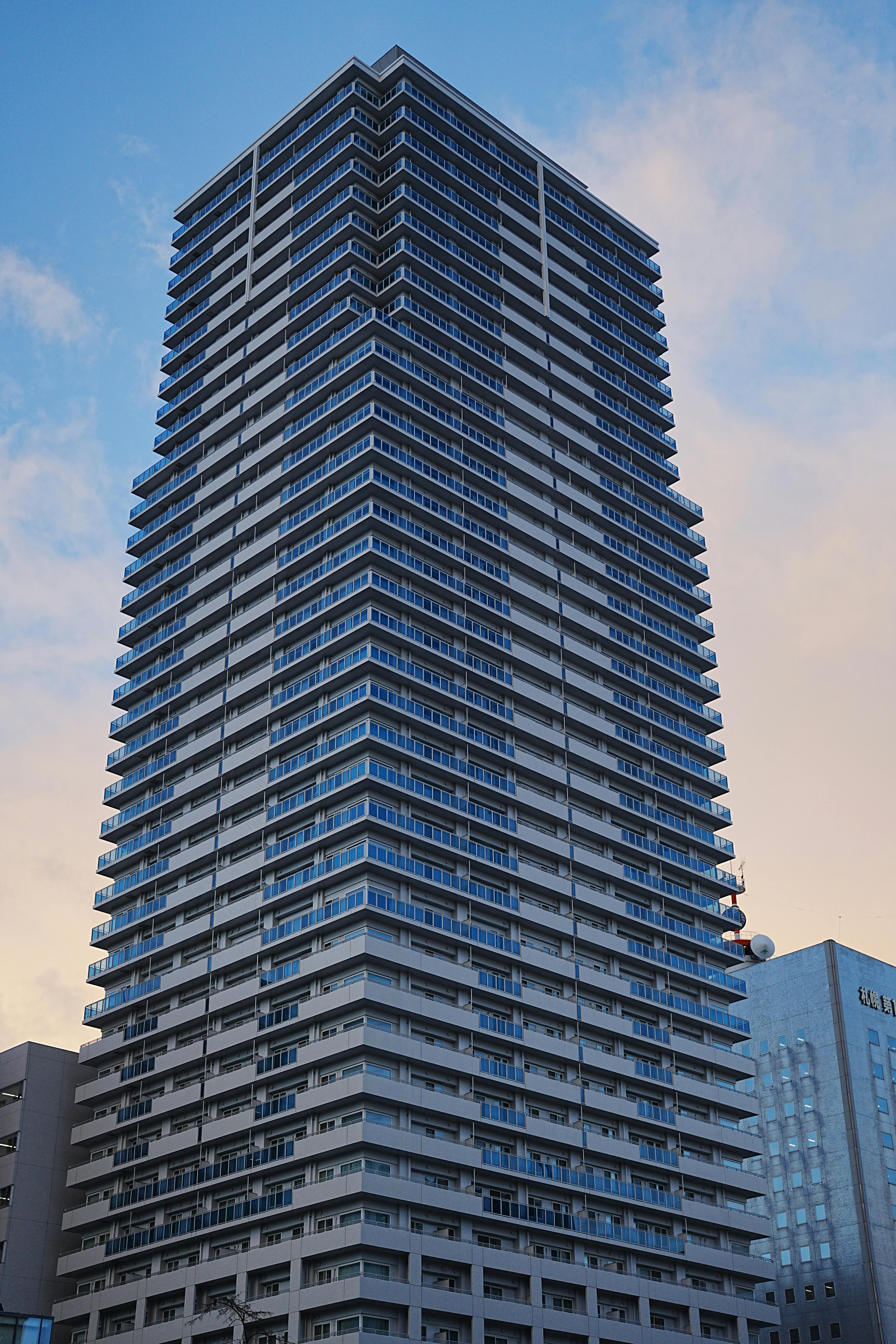 Modern high-rise building against blue sky · Free Stock Photo