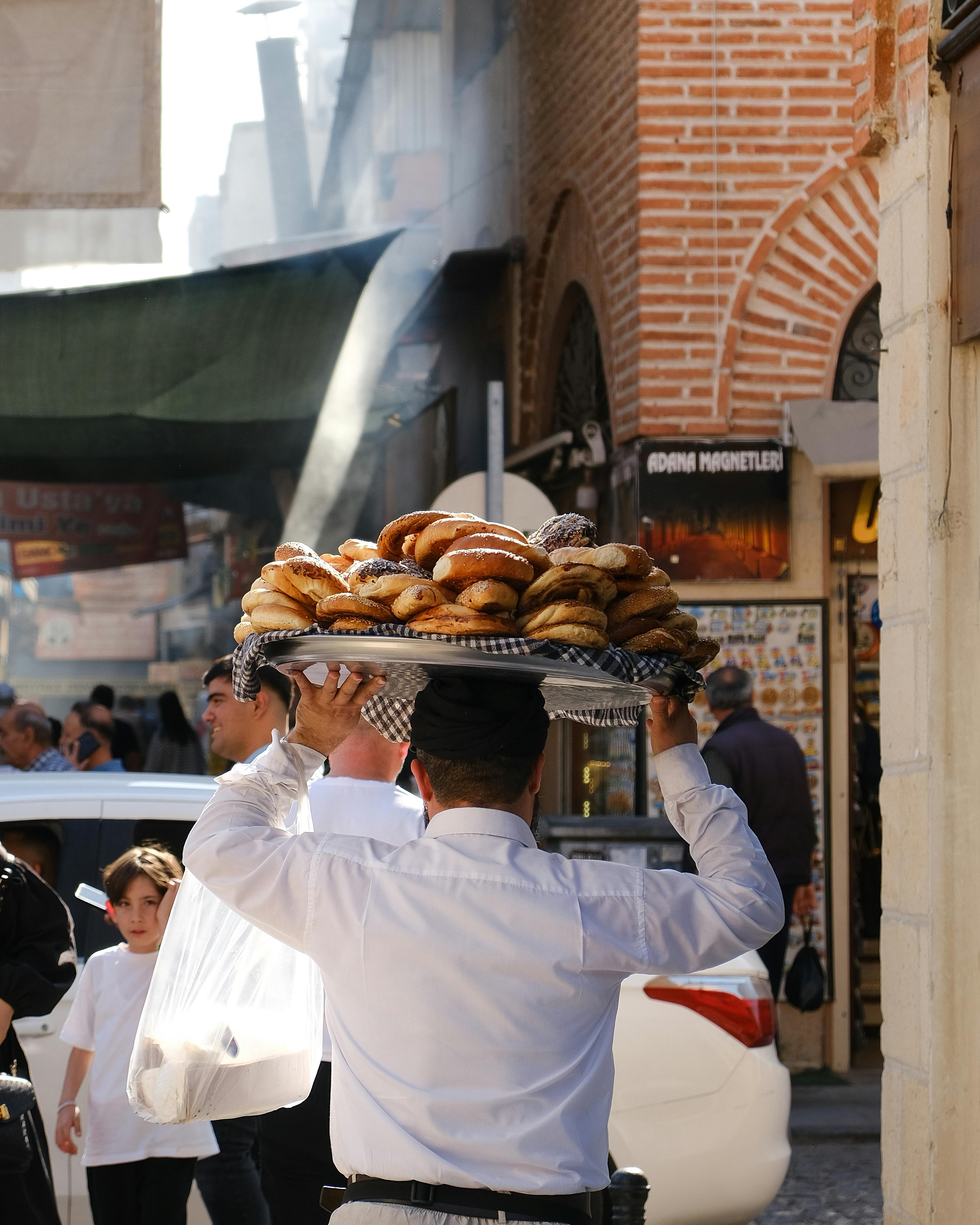 Street Vendor Carrying Fresh Bread on Bustling City Street · Free Stock ...