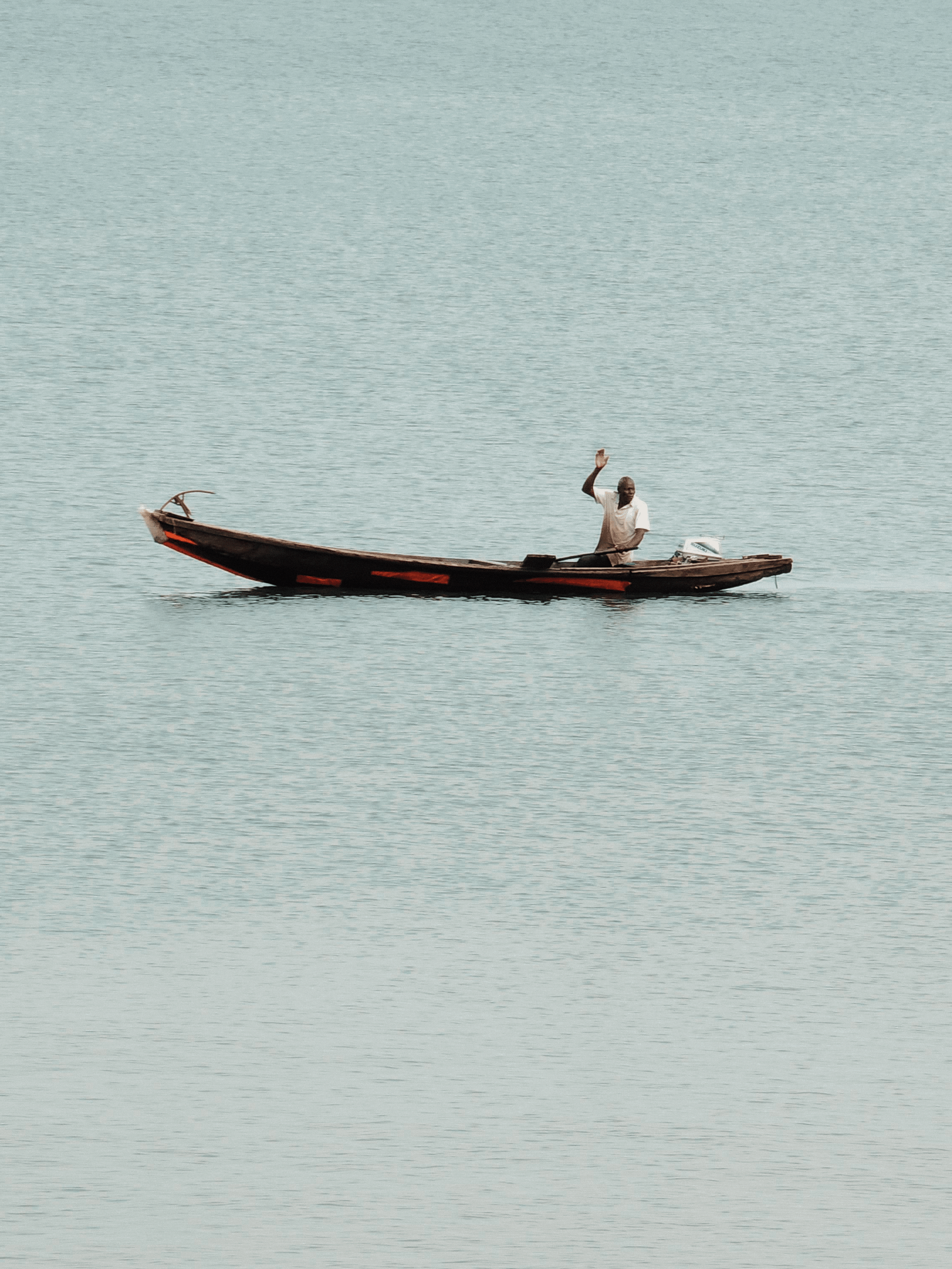 A Man Rowing A Small Boat With a Sail · Free Stock Photo