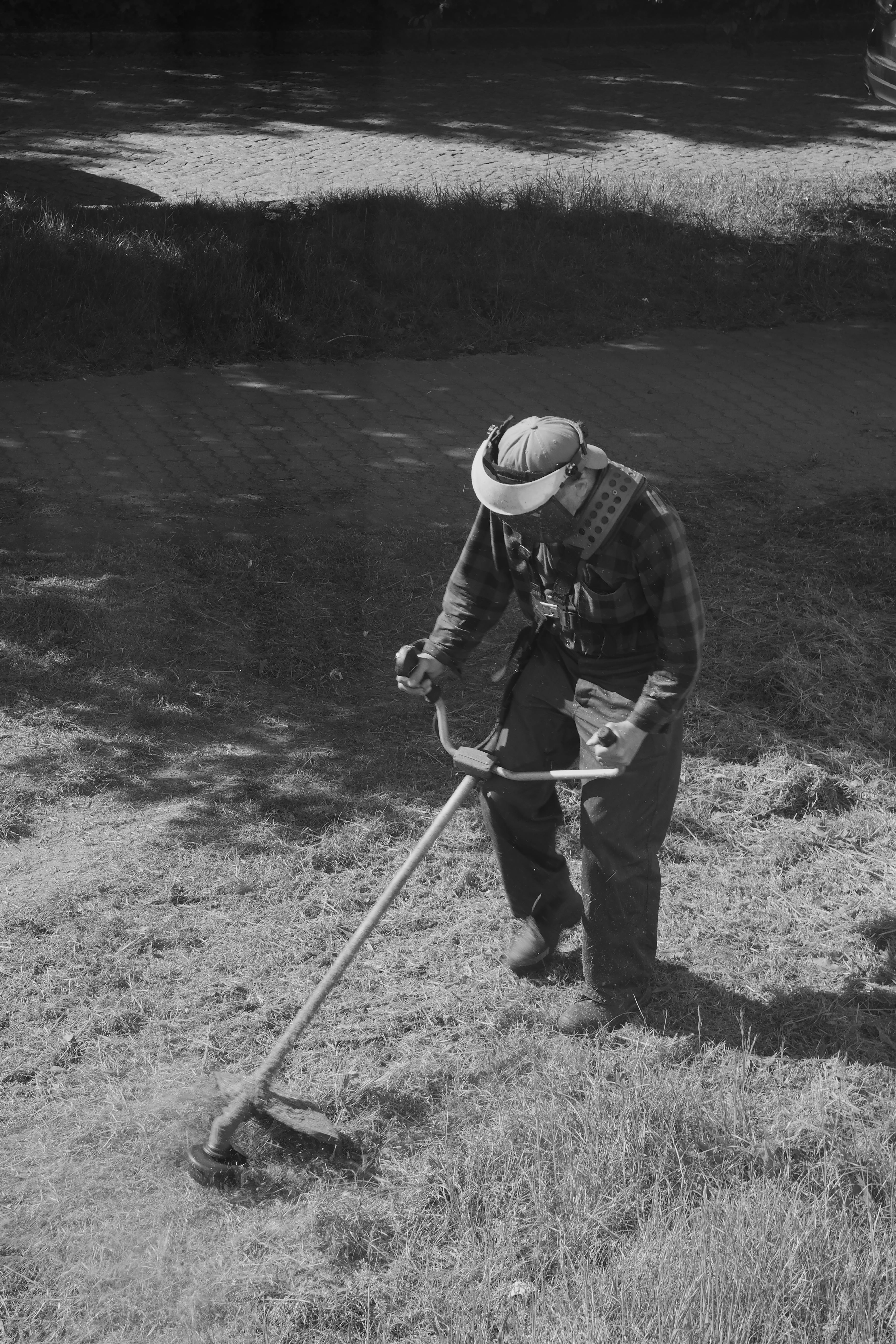 Man in Protective Gear Using a Weed Trimmer · Free Stock Photo