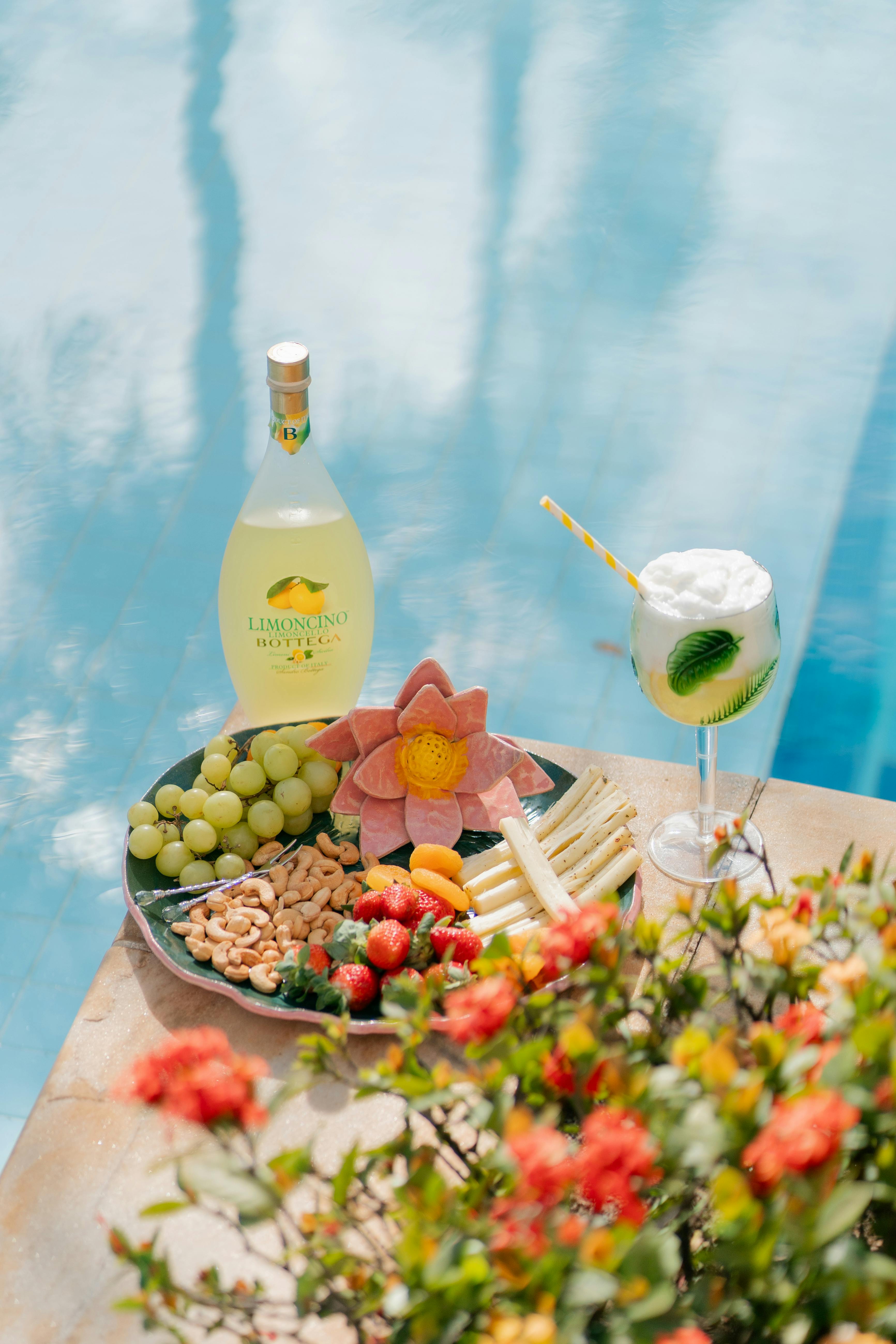 Refreshing Poolside Lemon Drink with Fruit Platter · Free Stock Photo