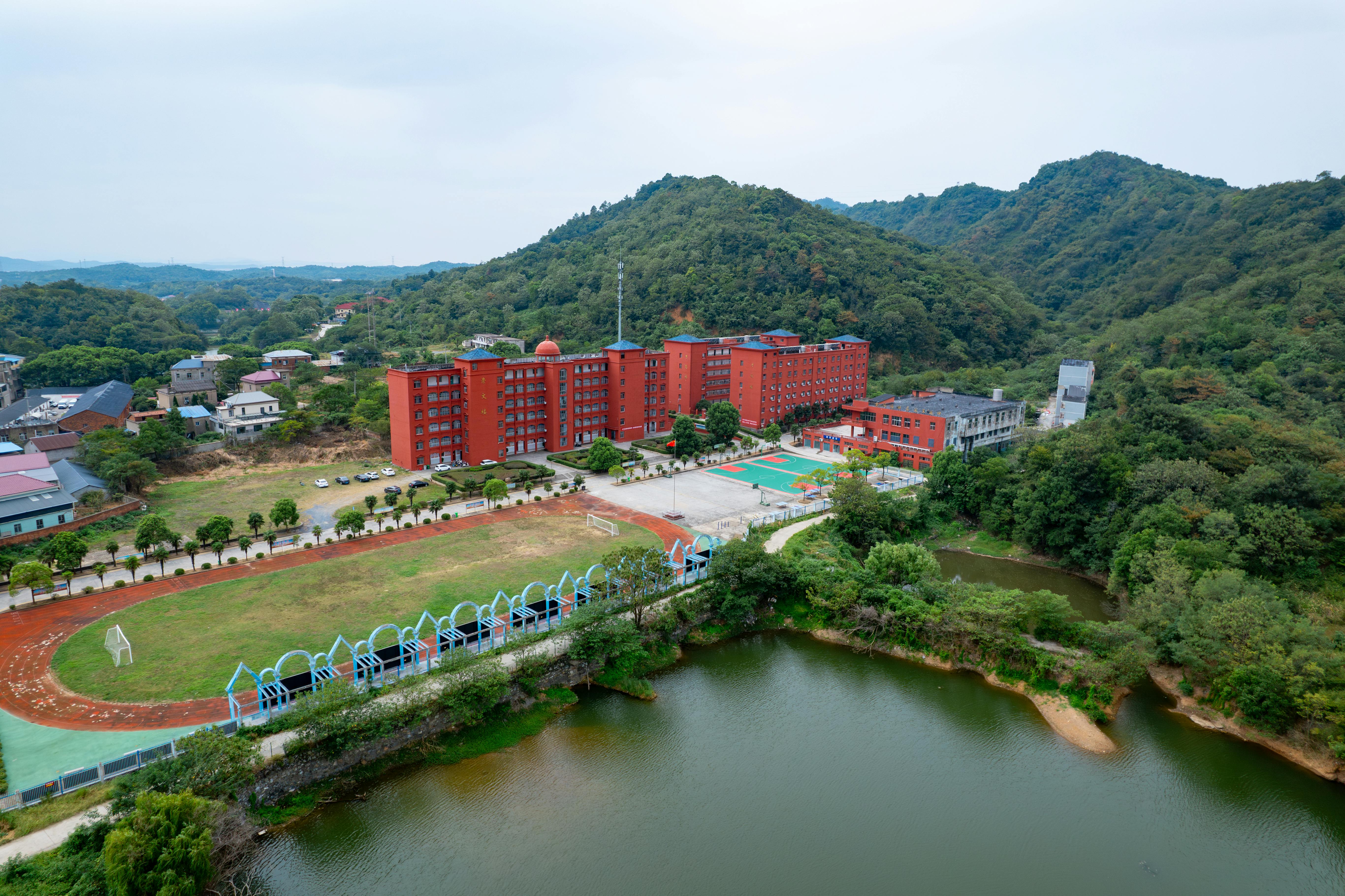 Aerial View of Red Brick Campus in Lush Valley · Free Stock Photo