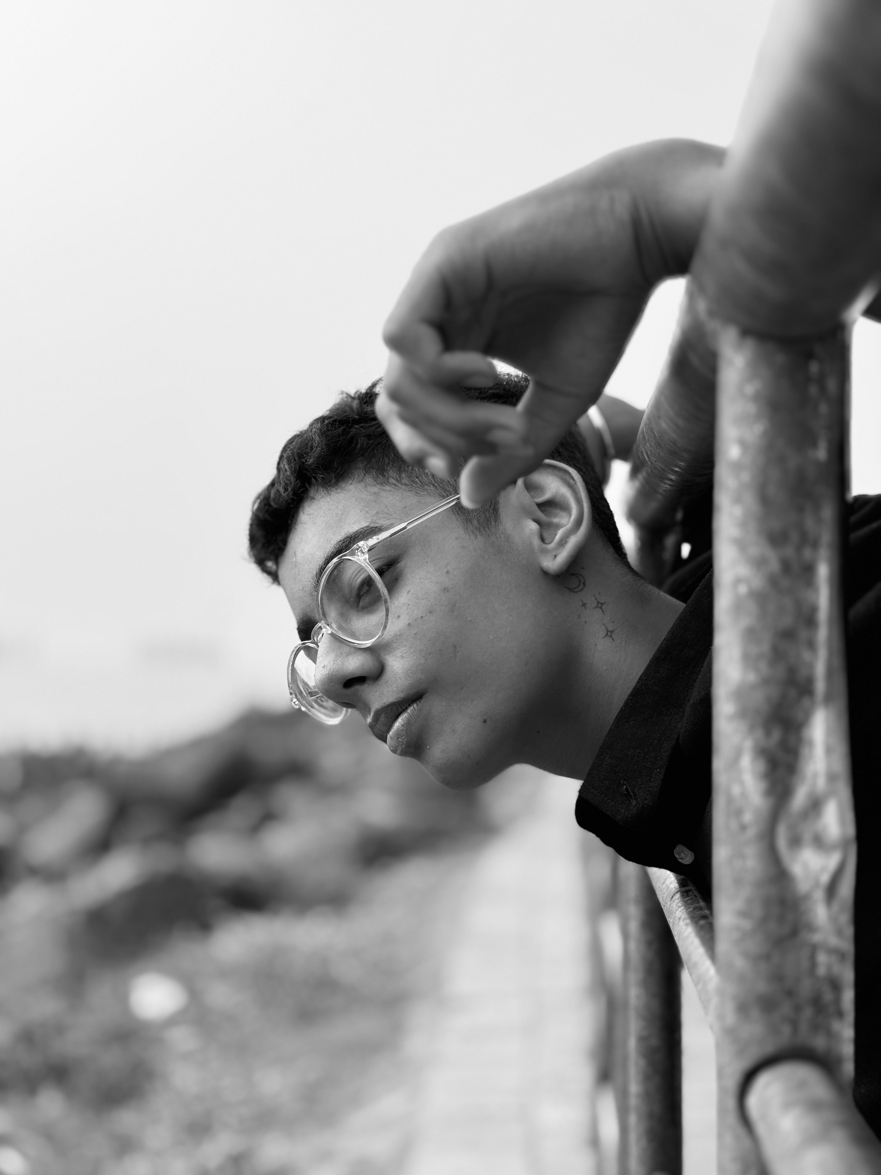 Contemplative Person Leaning on Rail Outdoors · Free Stock Photo