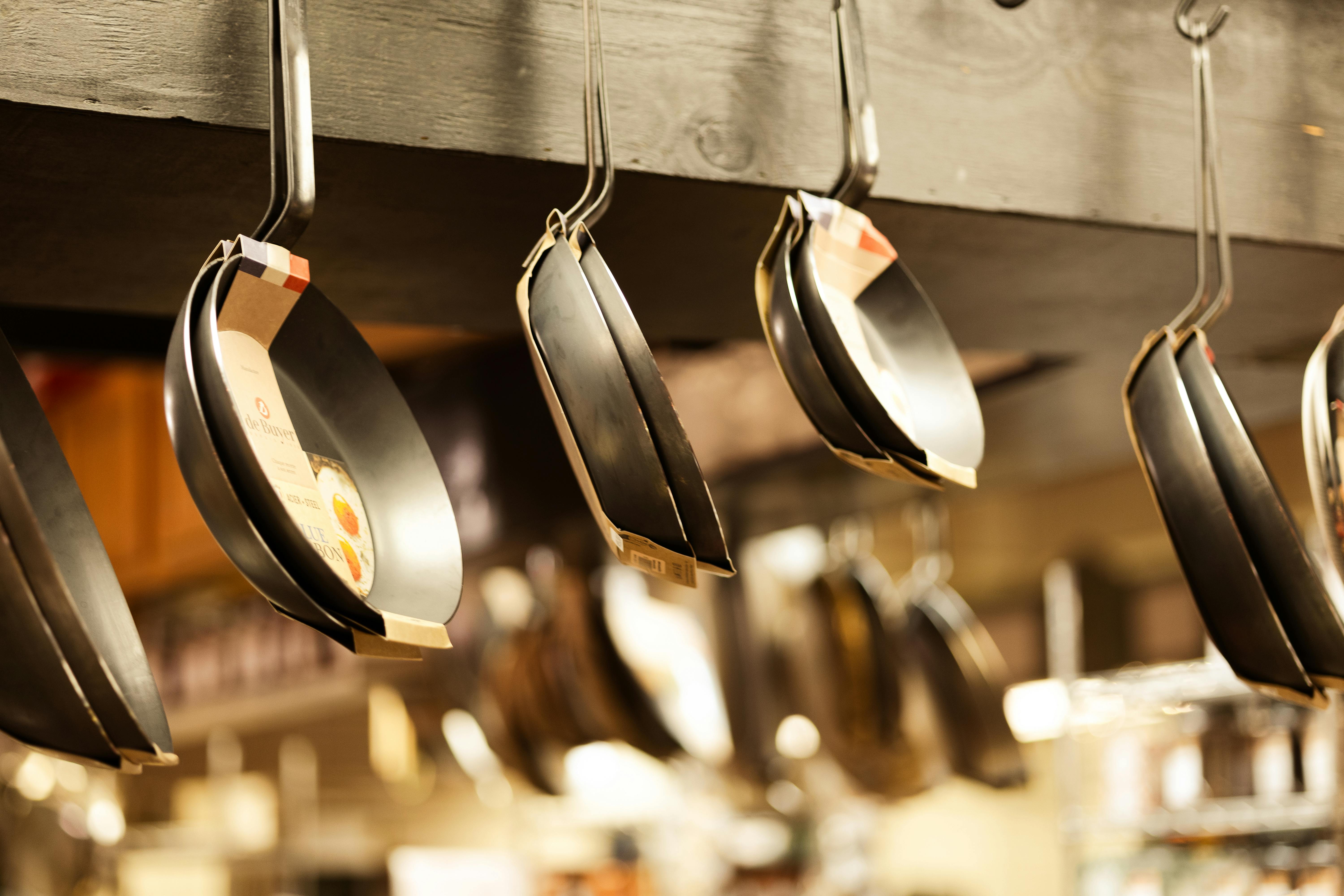 Hanging Frying Pans in Kitchen Store Display · Free Stock Photo