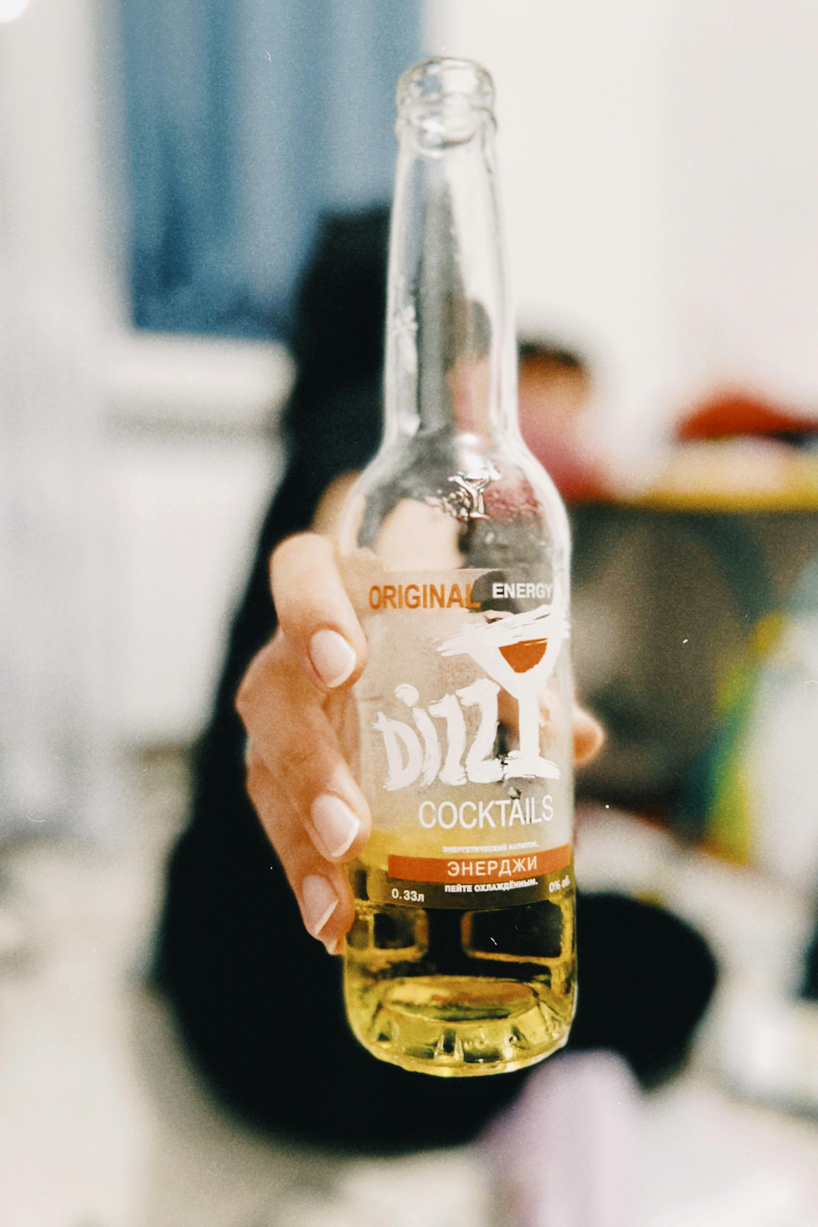 Close-Up of Hand Holding Dizz Cocktails Bottle · Free Stock Photo