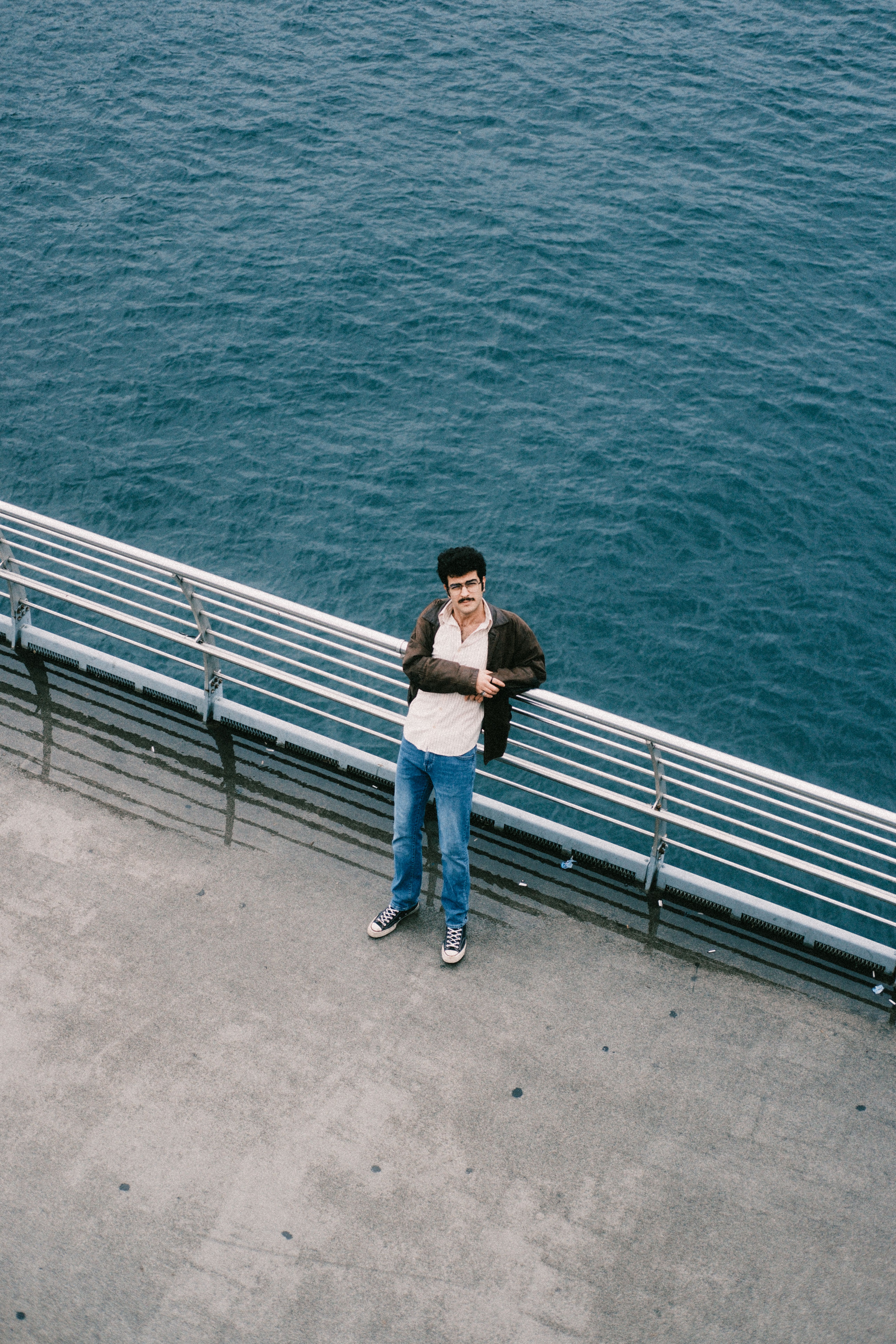 Man Posing on Pier with Ocean Background · Free Stock Photo