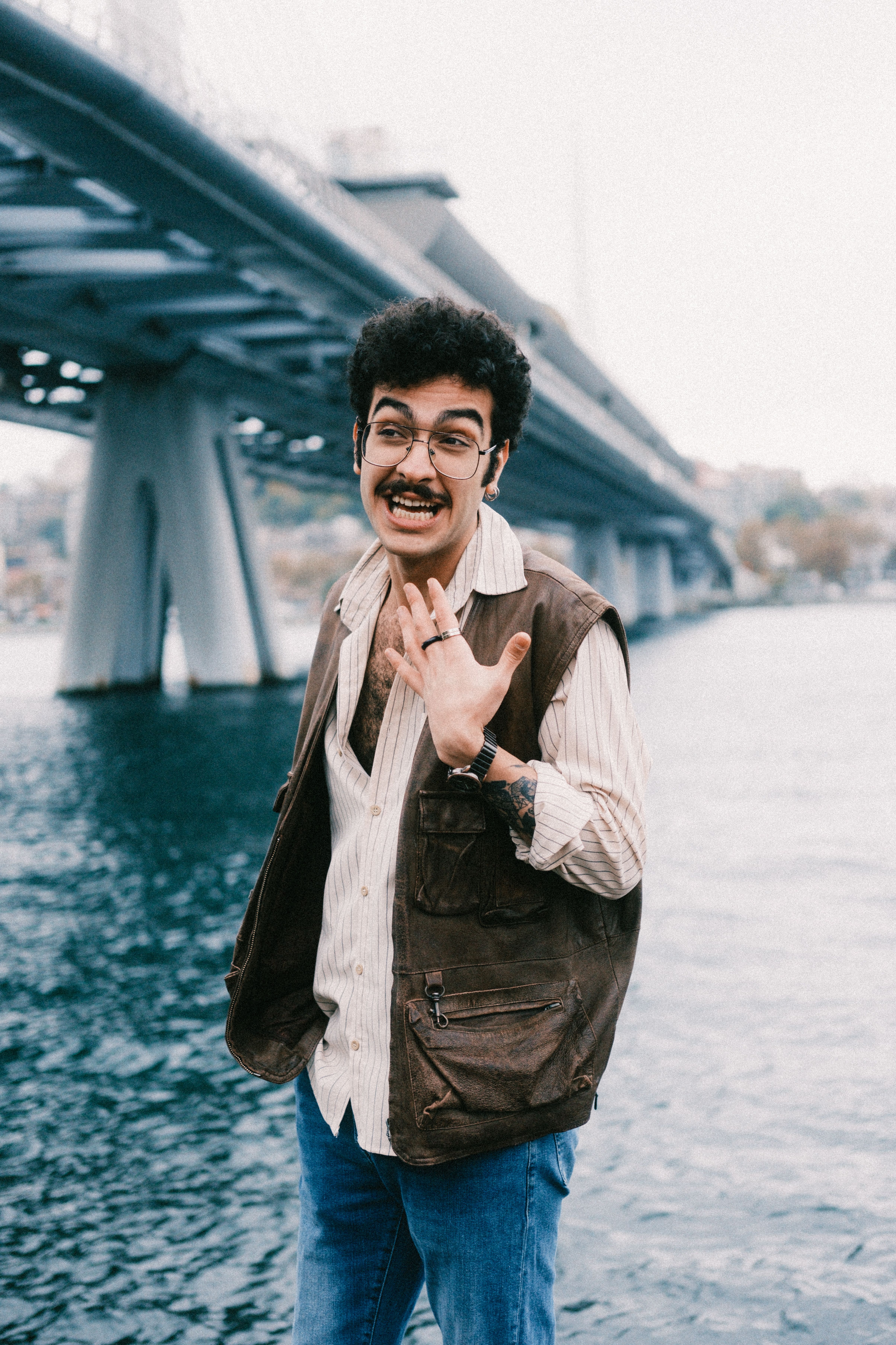 Smiling Man Posing Under Urban Bridge · Free Stock Photo