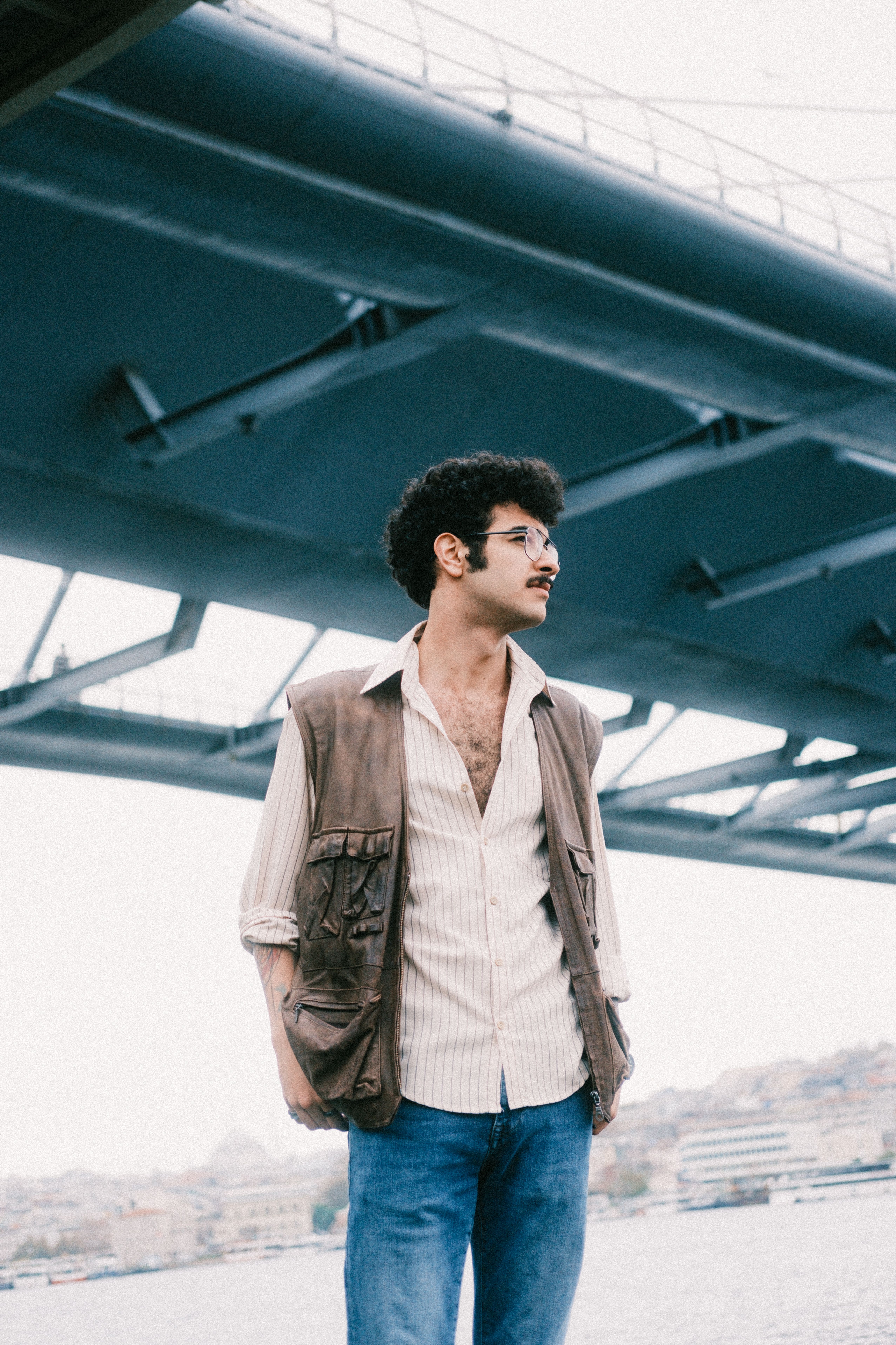Young Man Stands Confidently Under Urban Bridge · Free Stock Photo