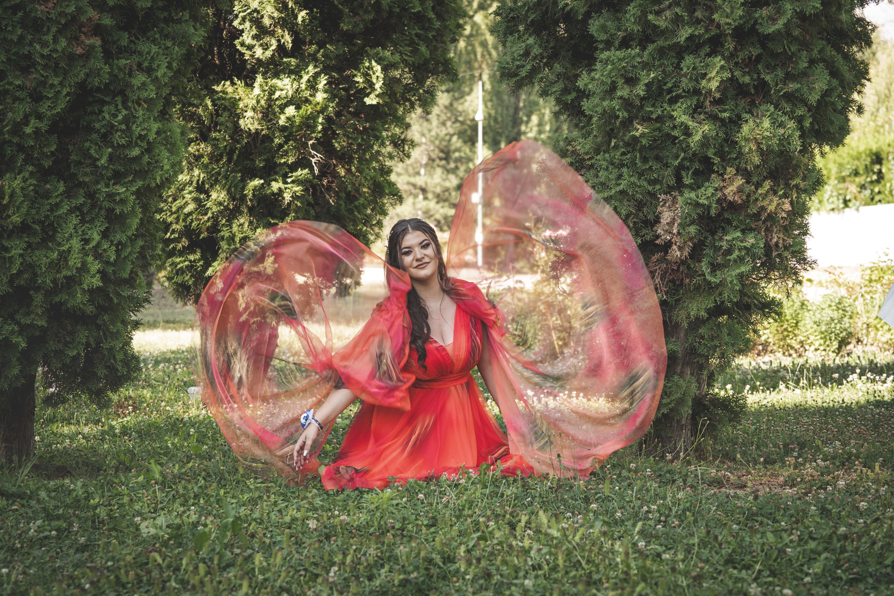 Elegant Woman in Flowing Red Dress Outdoors · Free Stock Photo