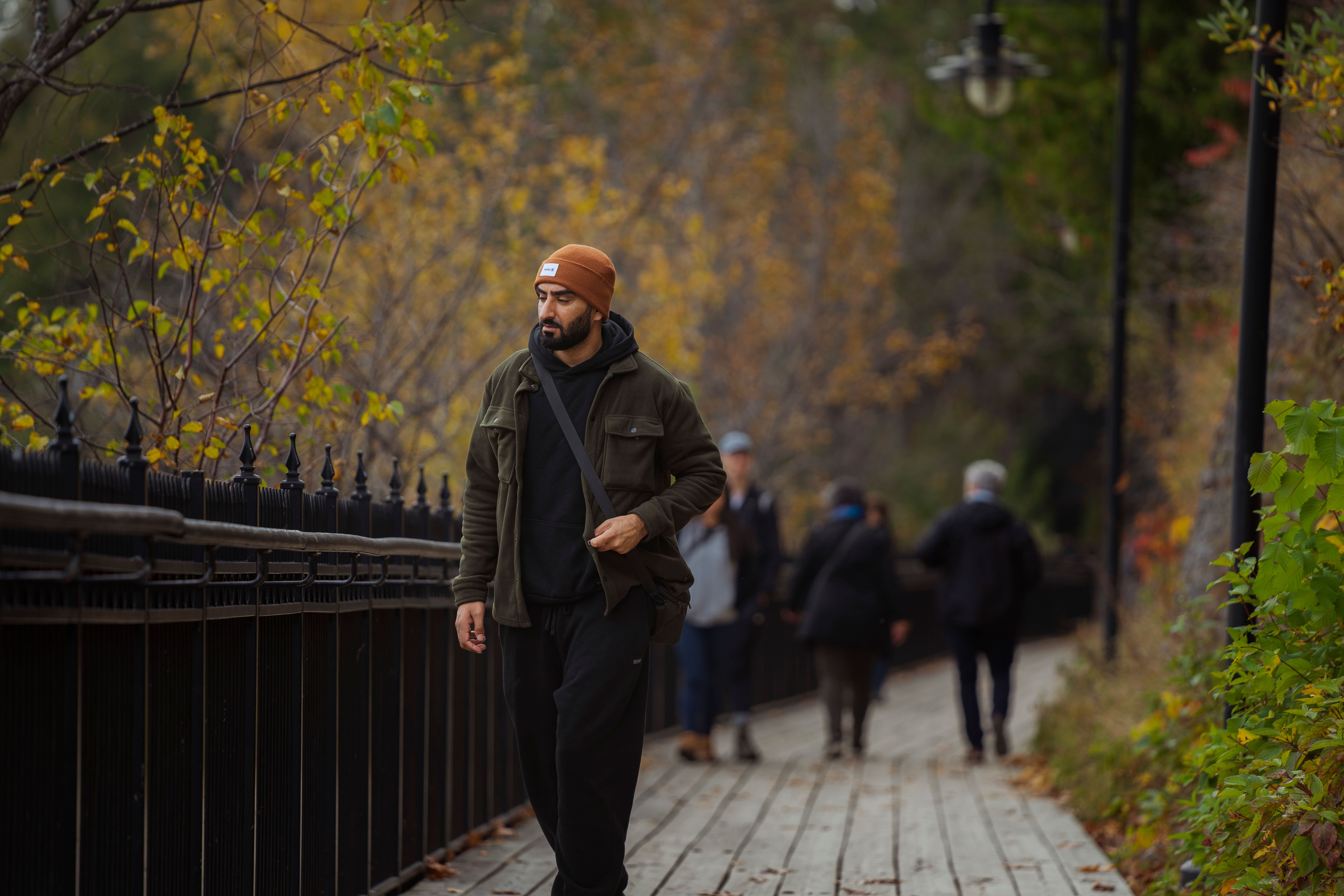 Man Walking on Leaf-Covered Autumn Pathway · Free Stock Photo