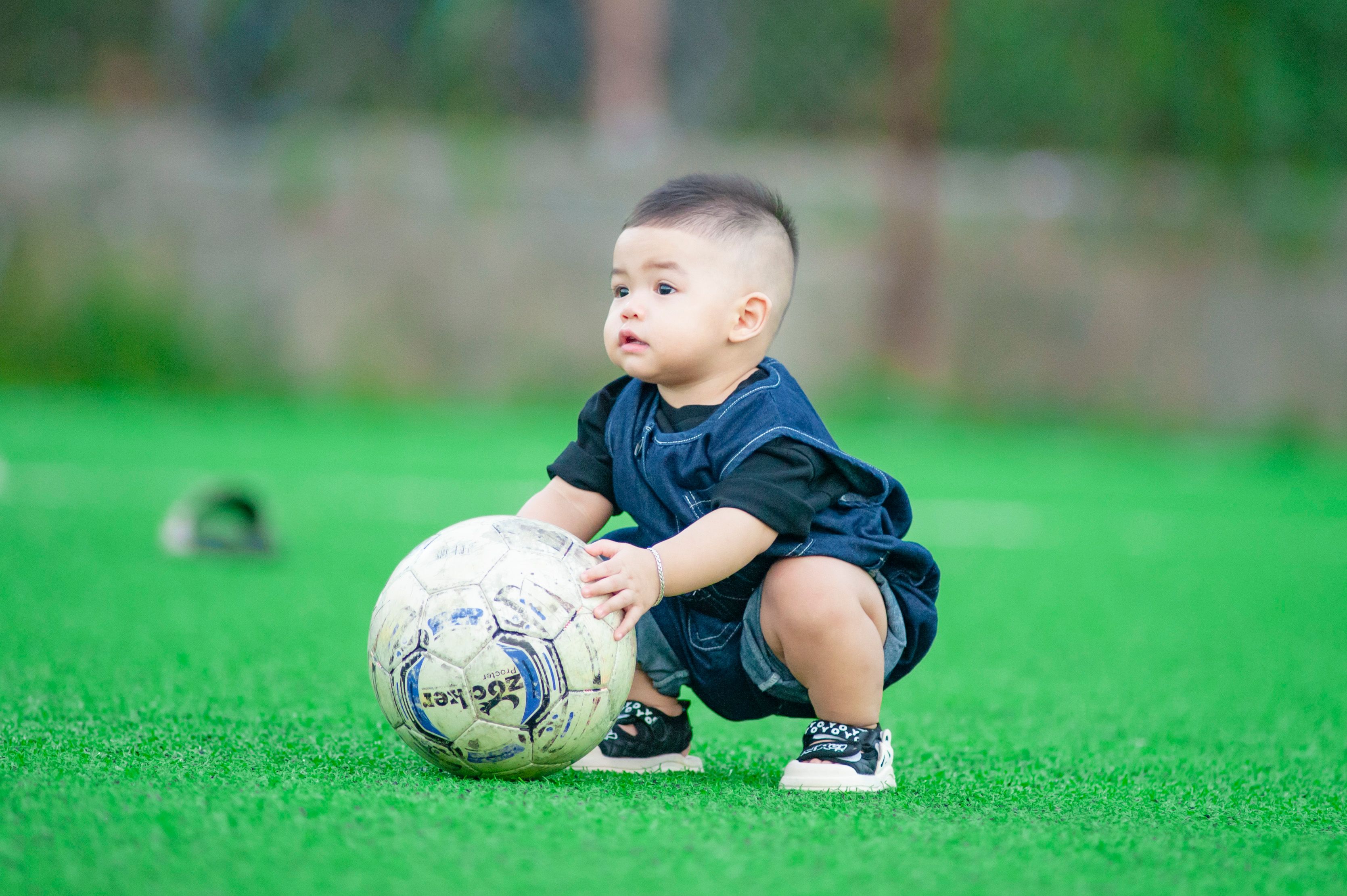Bebê Brincando Com Bola De Futebol No Campo De Grama · Foto ...