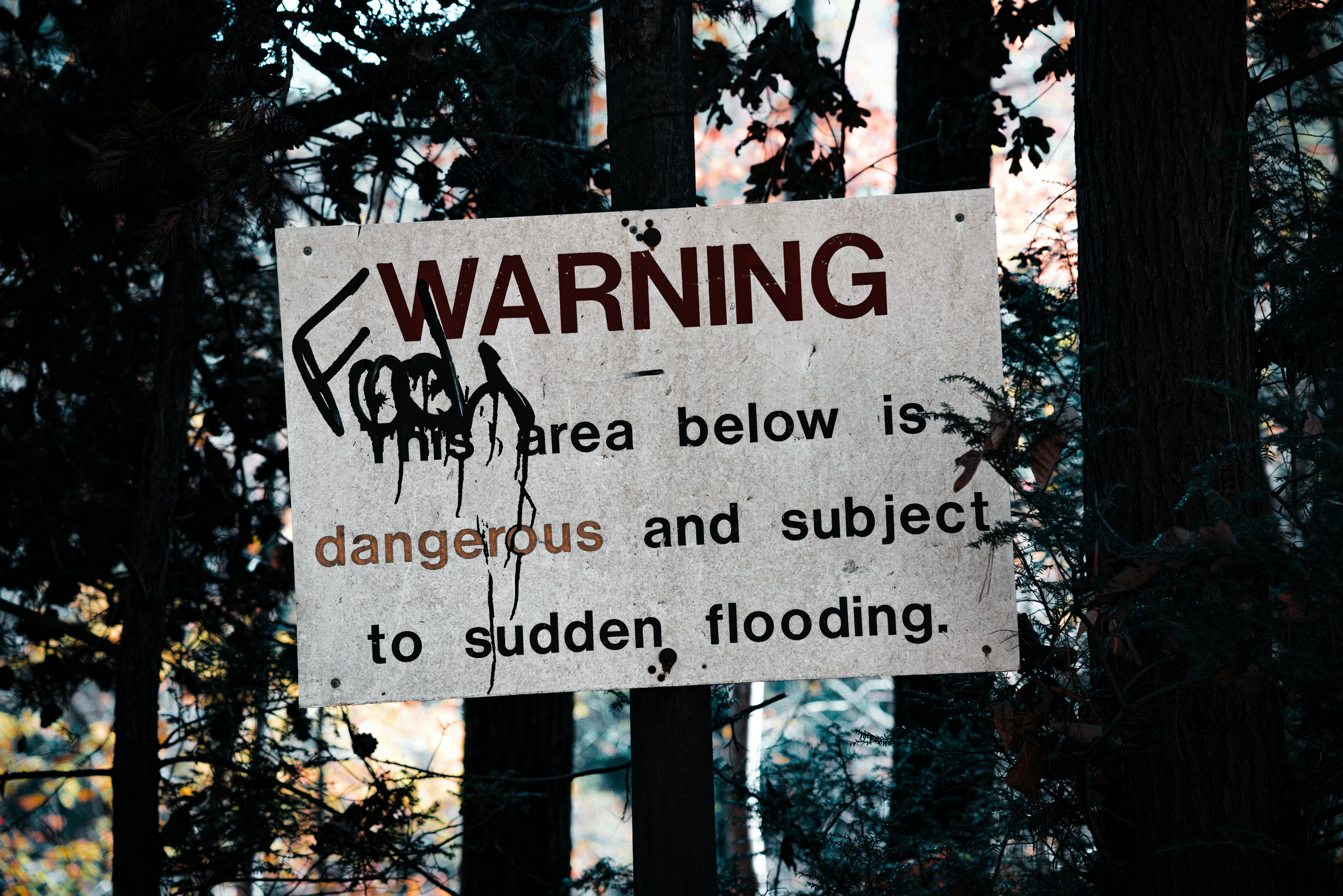Warning Sign for Flooding in Forested Area · Free Stock Photo