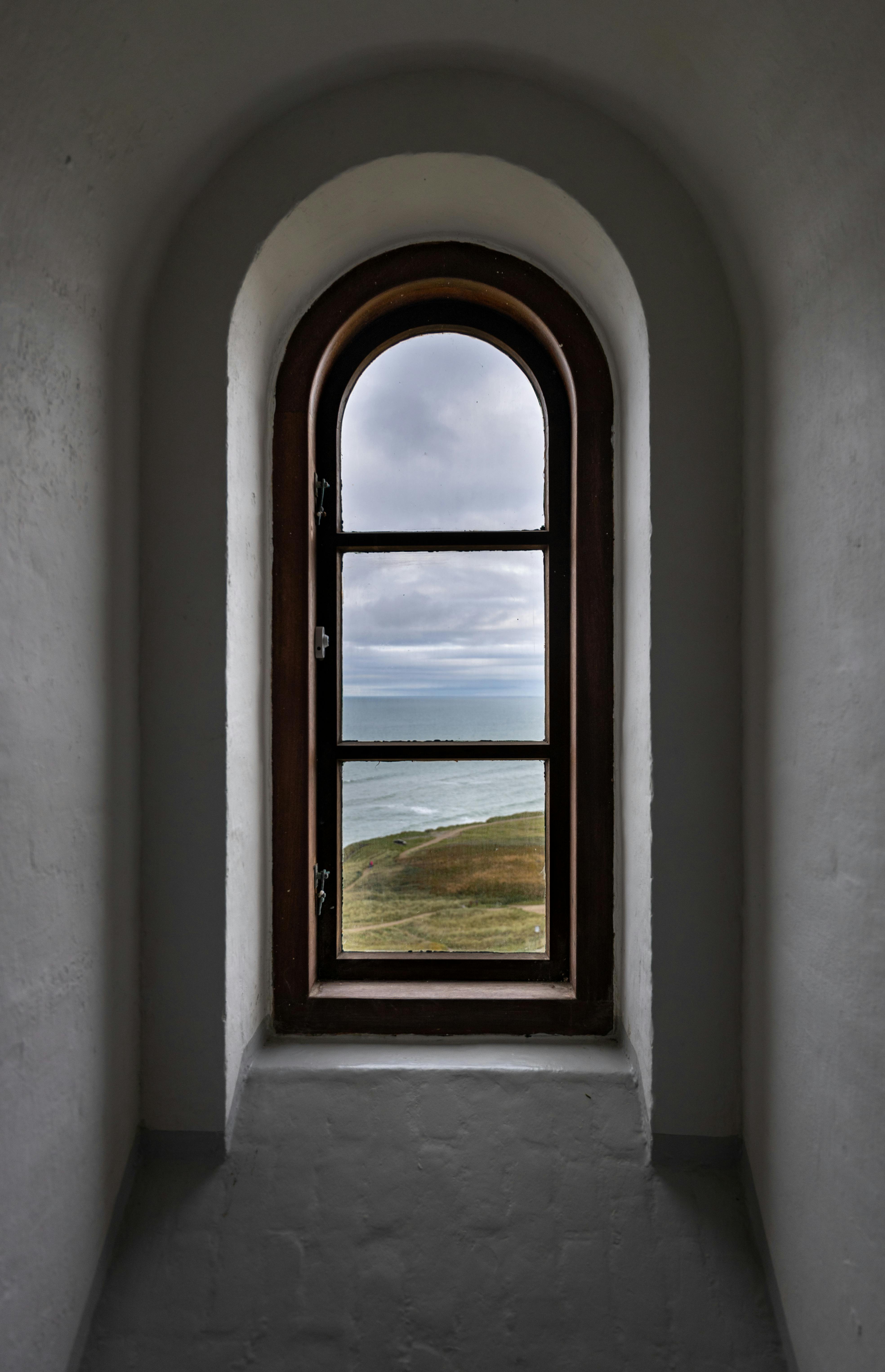 Scenic Coastal View Through Arched Window · Free Stock Photo