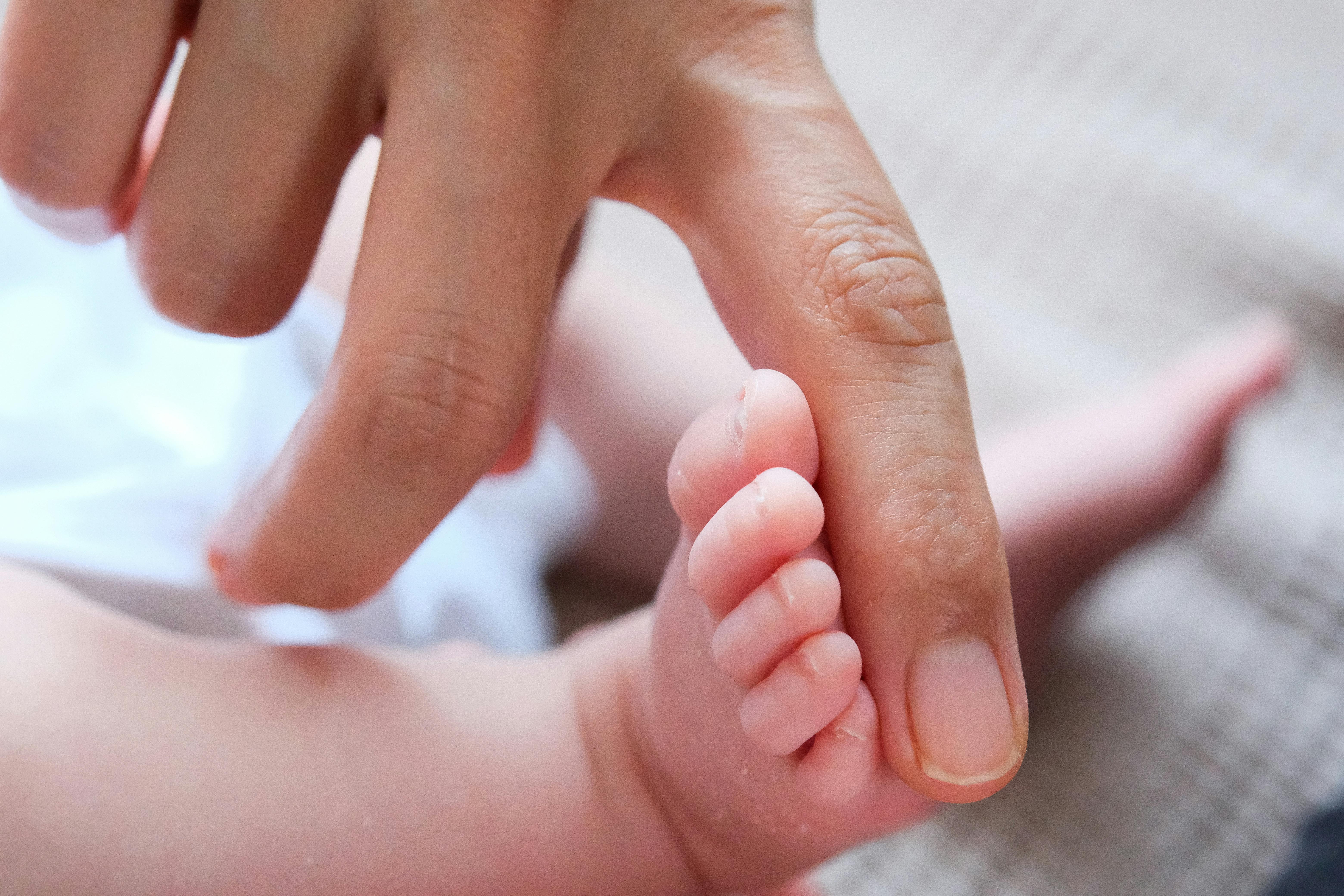 Teder Moment: Volwassen Vinger Raakt Baby's Tenen Aan · Gratis stockfoto