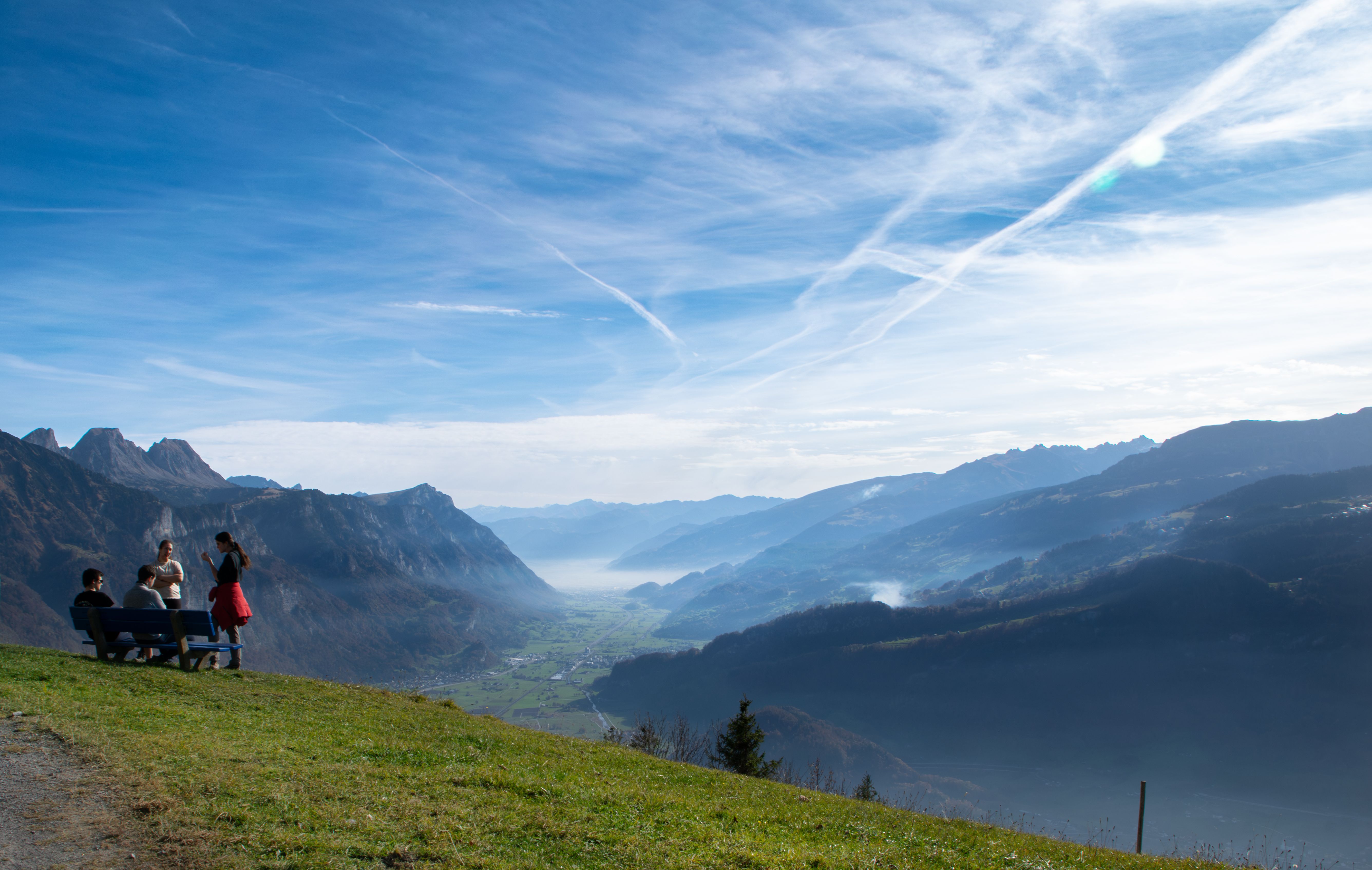 Scenic Mountain View with People Relaxing on Bench · Free Stock Photo