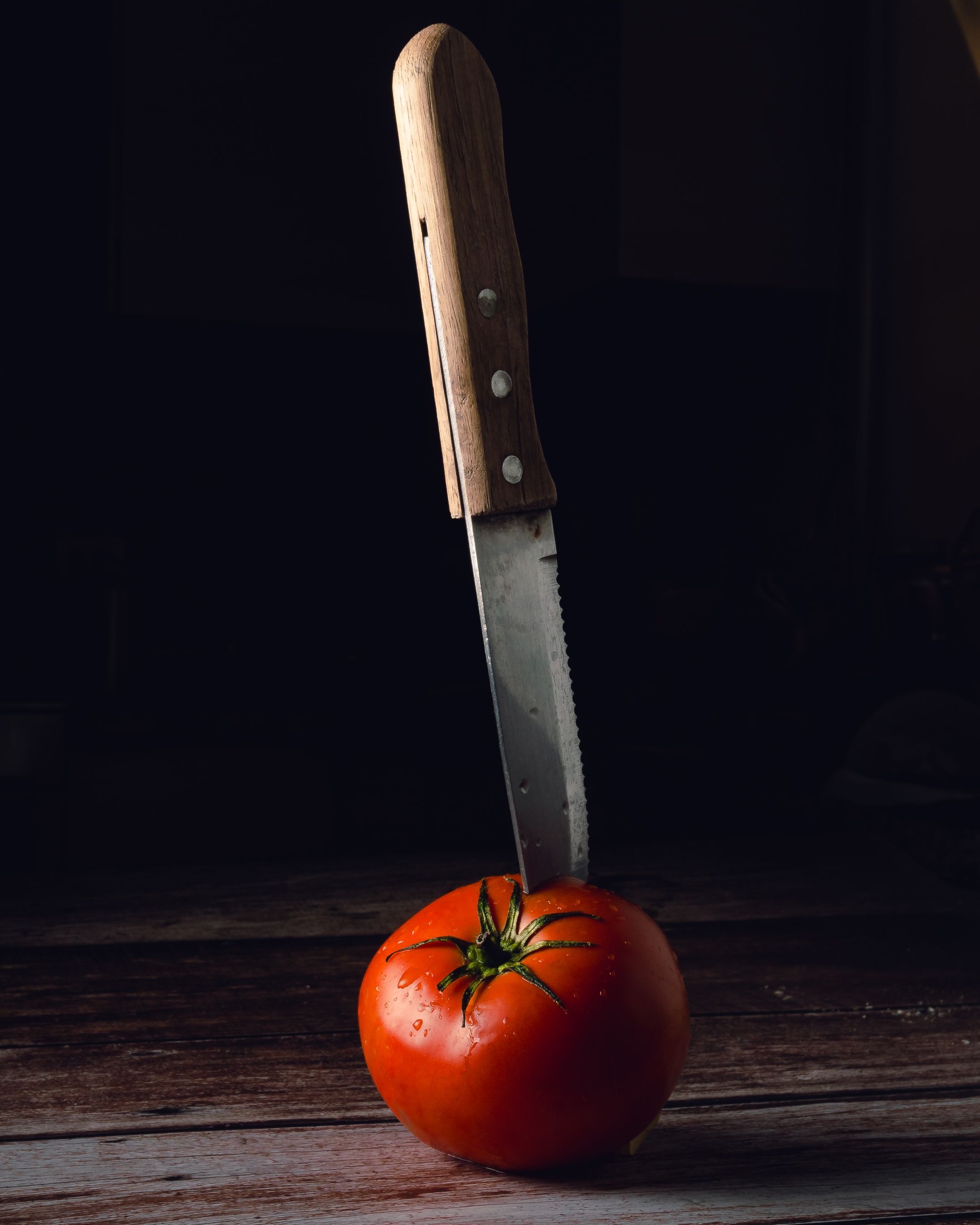 Sharp Knife Piercing Fresh Tomato on Wooden Table · Free Stock Photo