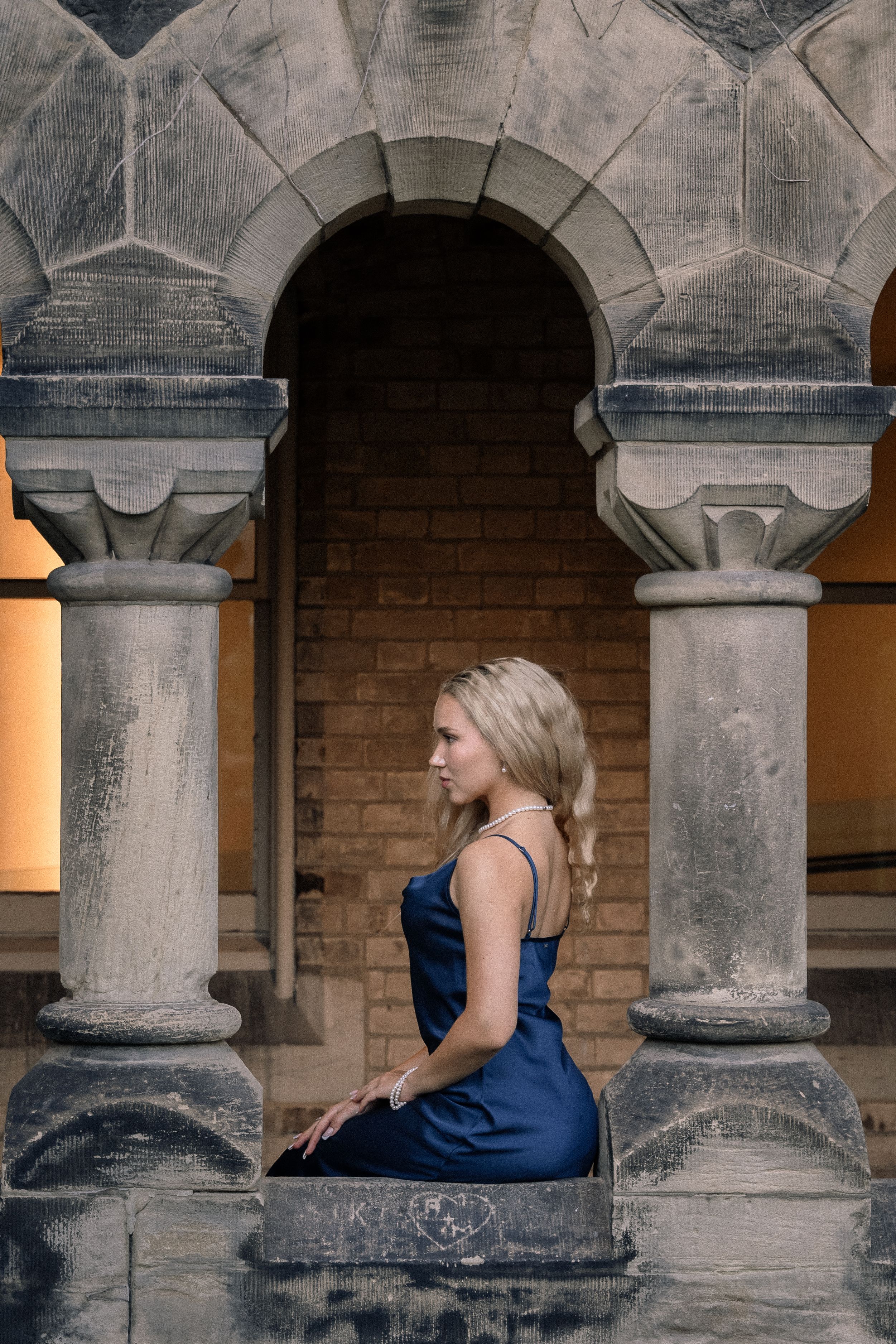 Elegant woman in blue dress framed by arches · Free Stock Photo