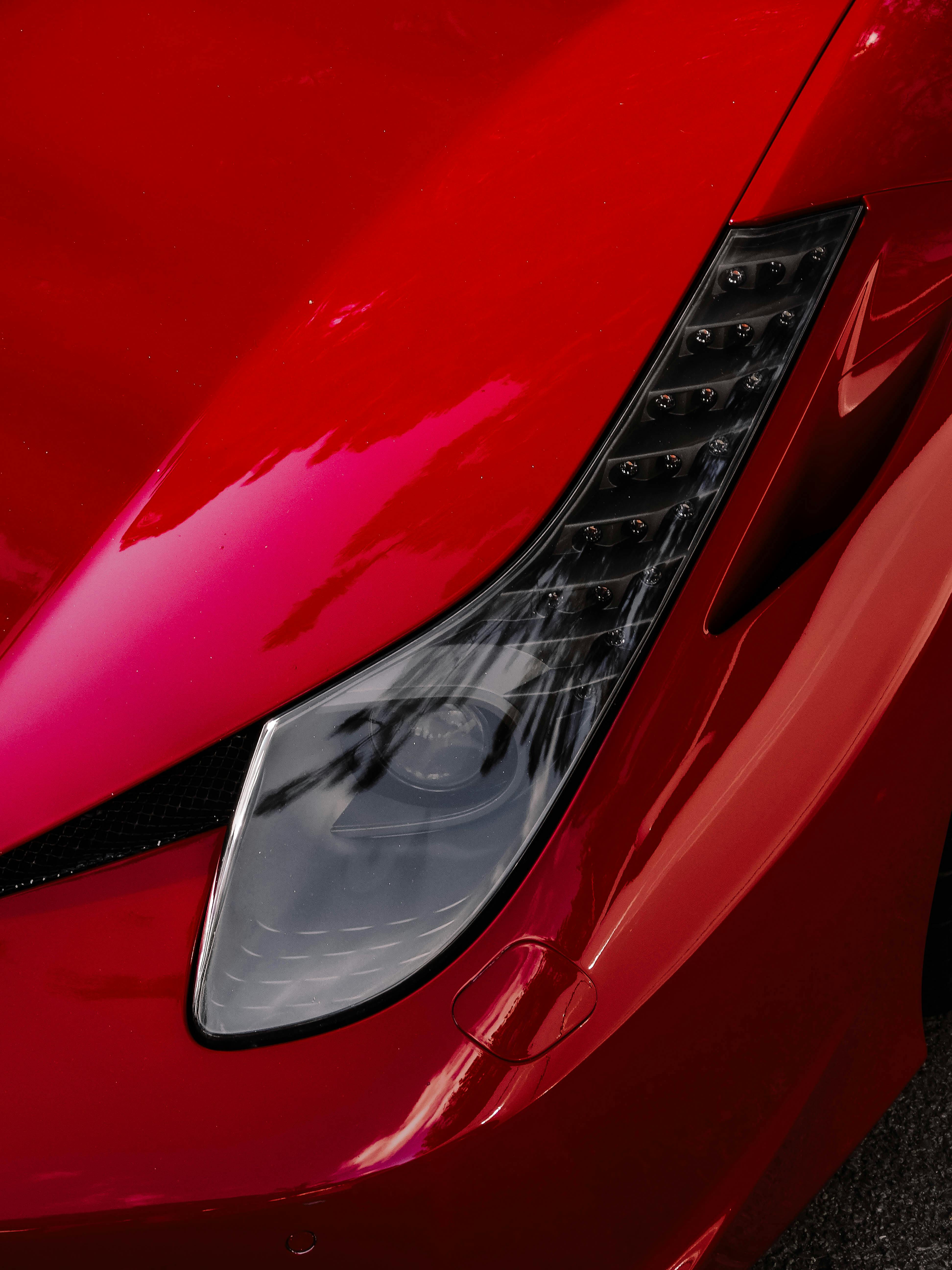 Close-Up of a Red Ferrari Headlight · Free Stock Photo