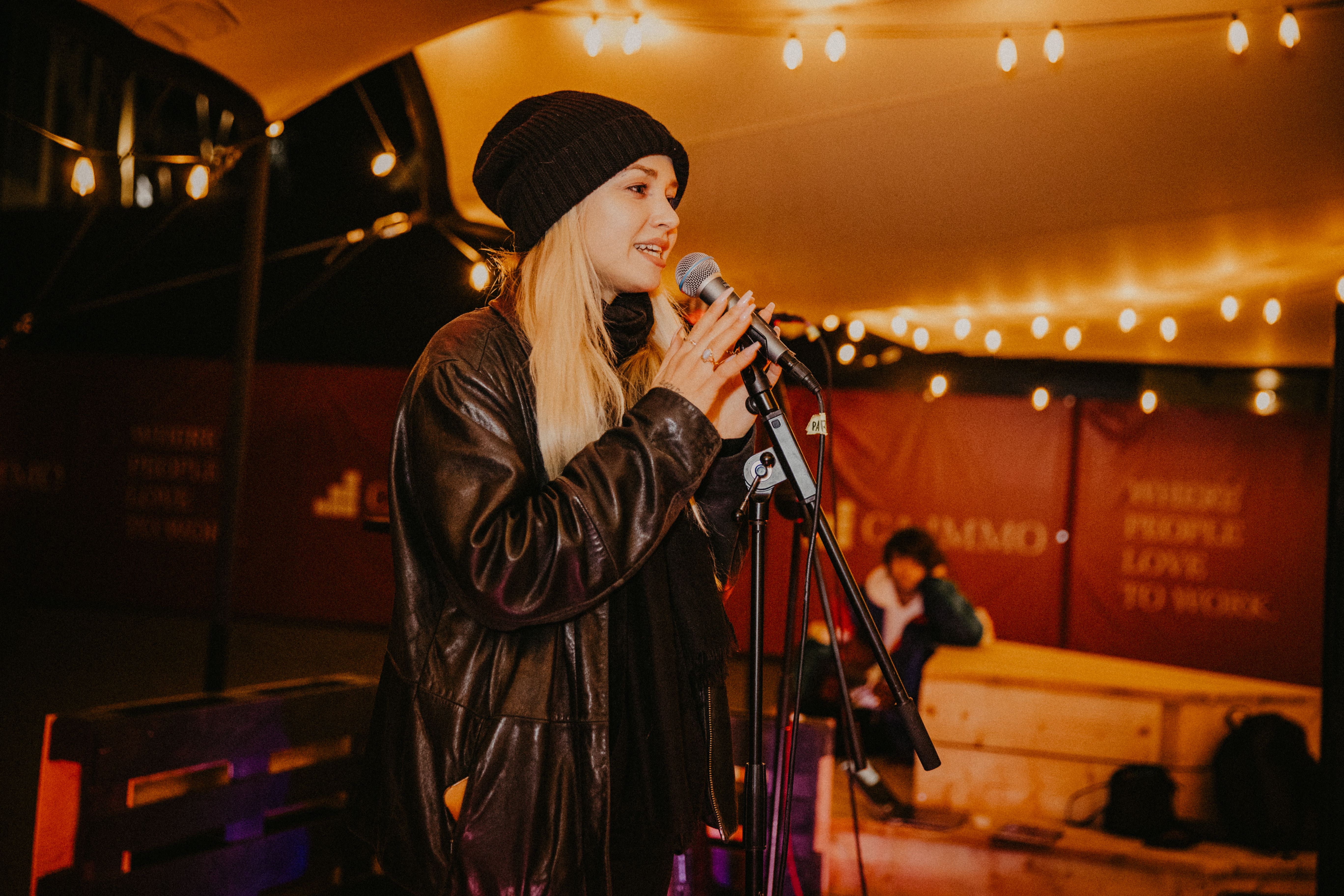 Young Woman Singing Outdoors at Night Event in Berlin · Free Stock Photo