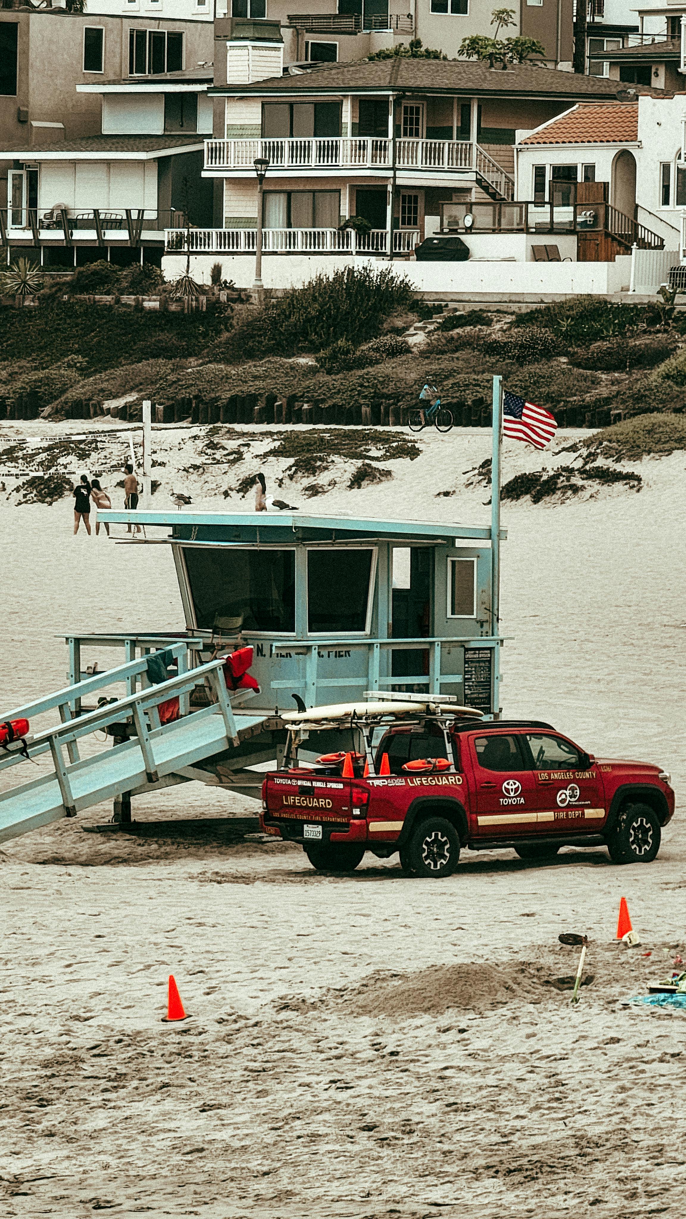 Lifeguard station with red truck on sandy beach · Free Stock Photo