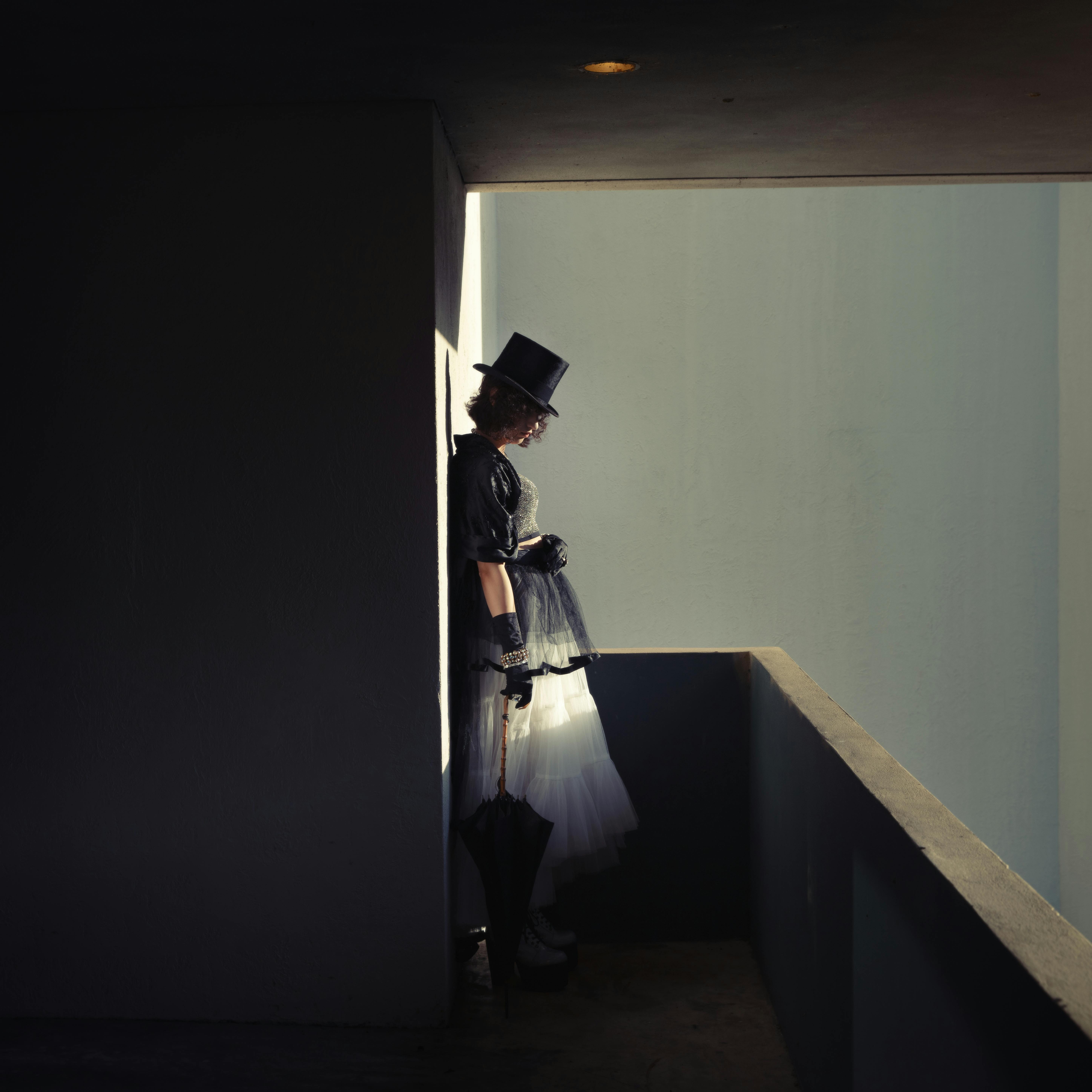 Mystical Figure in Victorian Attire in Shadowy Corridor · Free Stock Photo