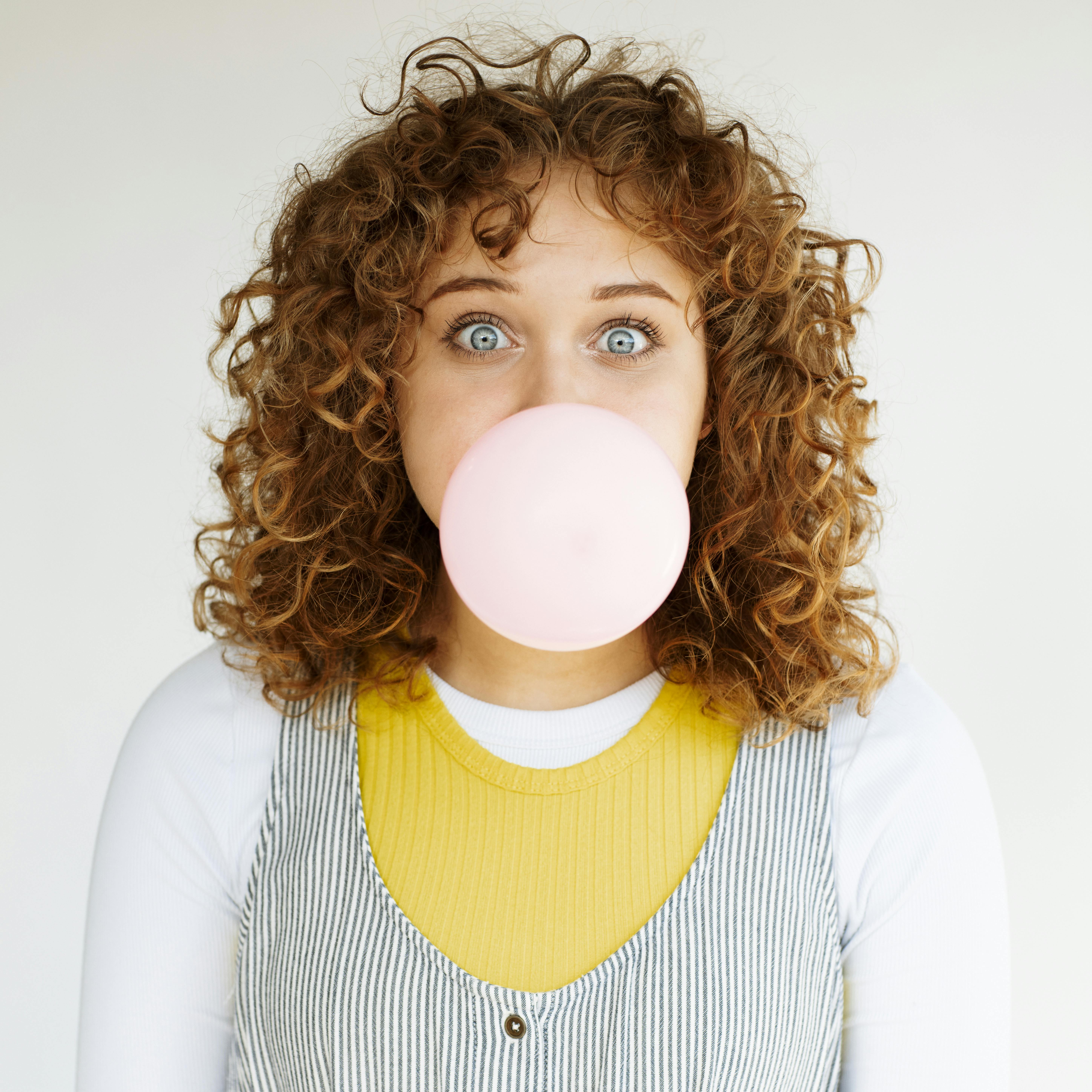 A Woman Eating a Bubble Gum · Free Stock Photo