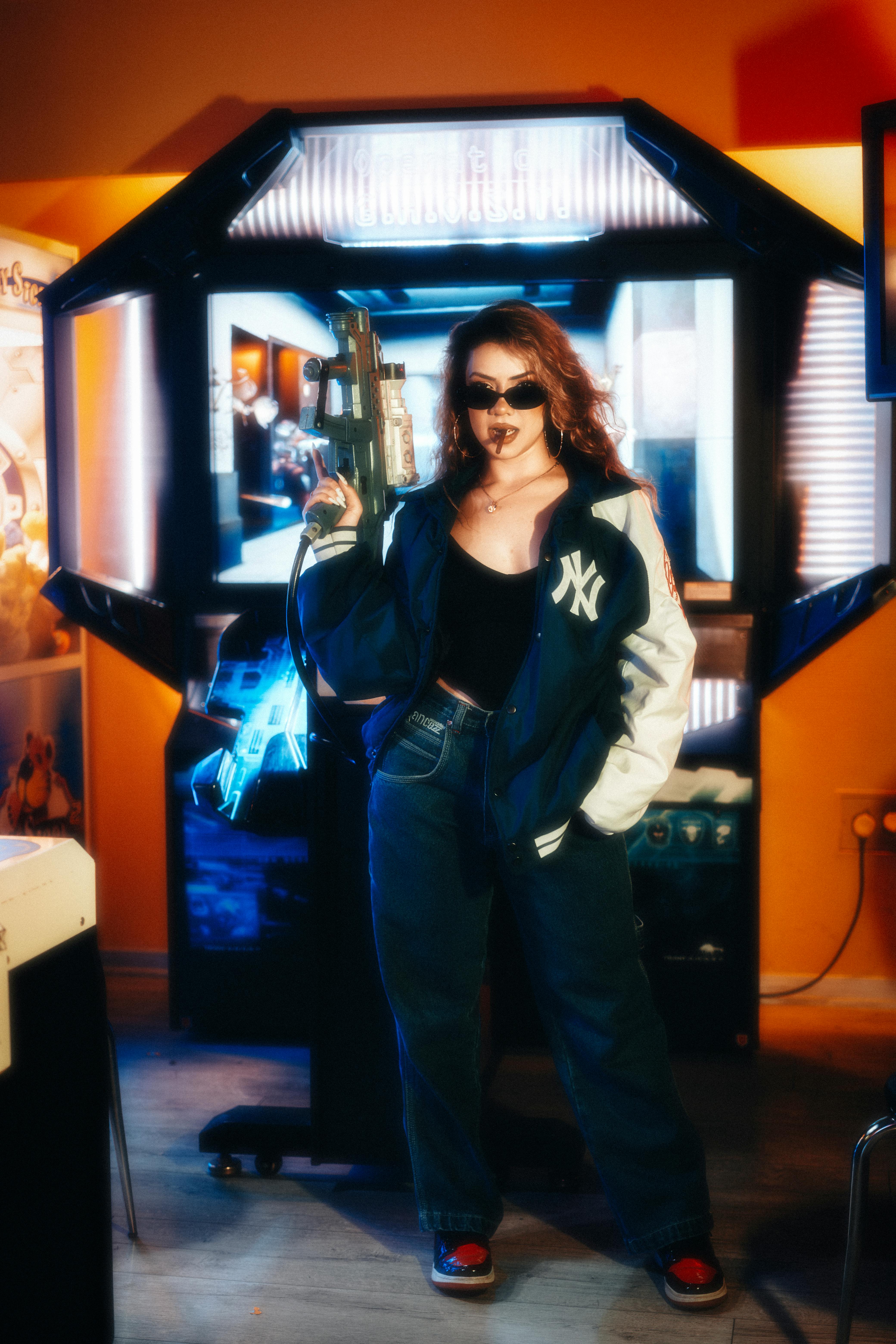 Retro Gaming Arcade with Stylish Gamer in Focus · Free Stock Photo