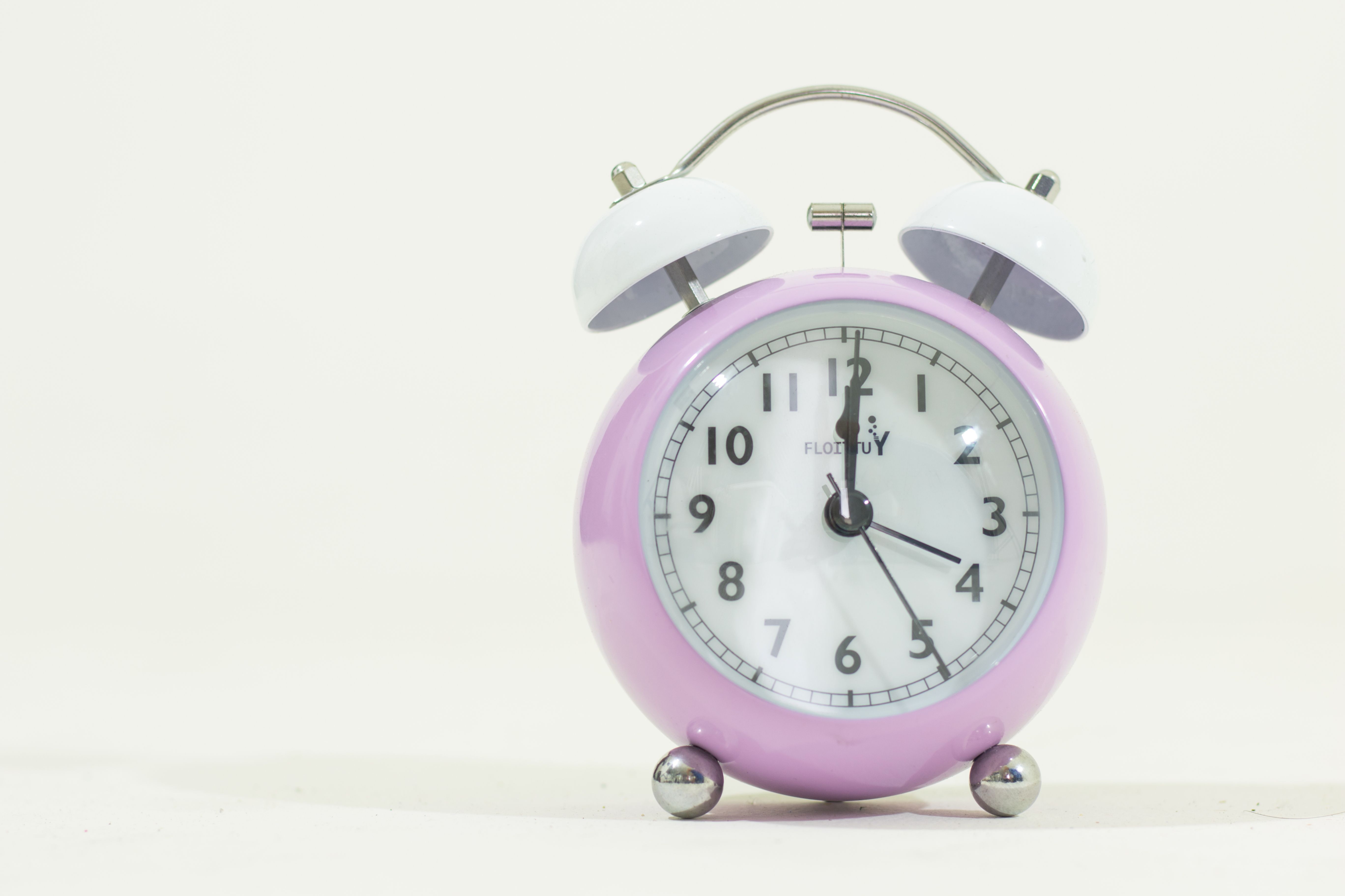 Minimalist Lilac Alarm Clock on White Background · Free Stock Photo