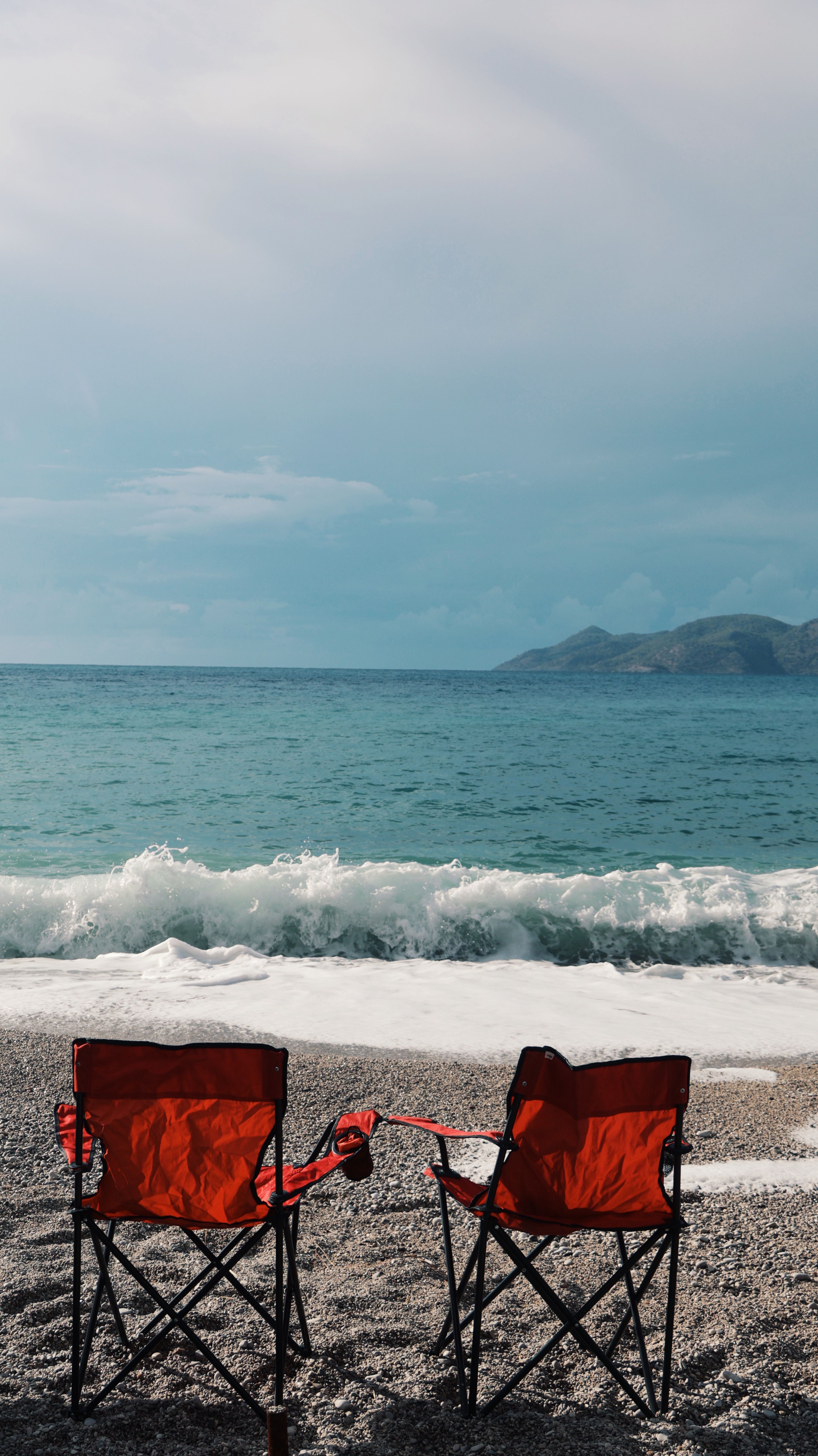 Relaxing Beach Scene with Two Red Chairs · Free Stock Photo