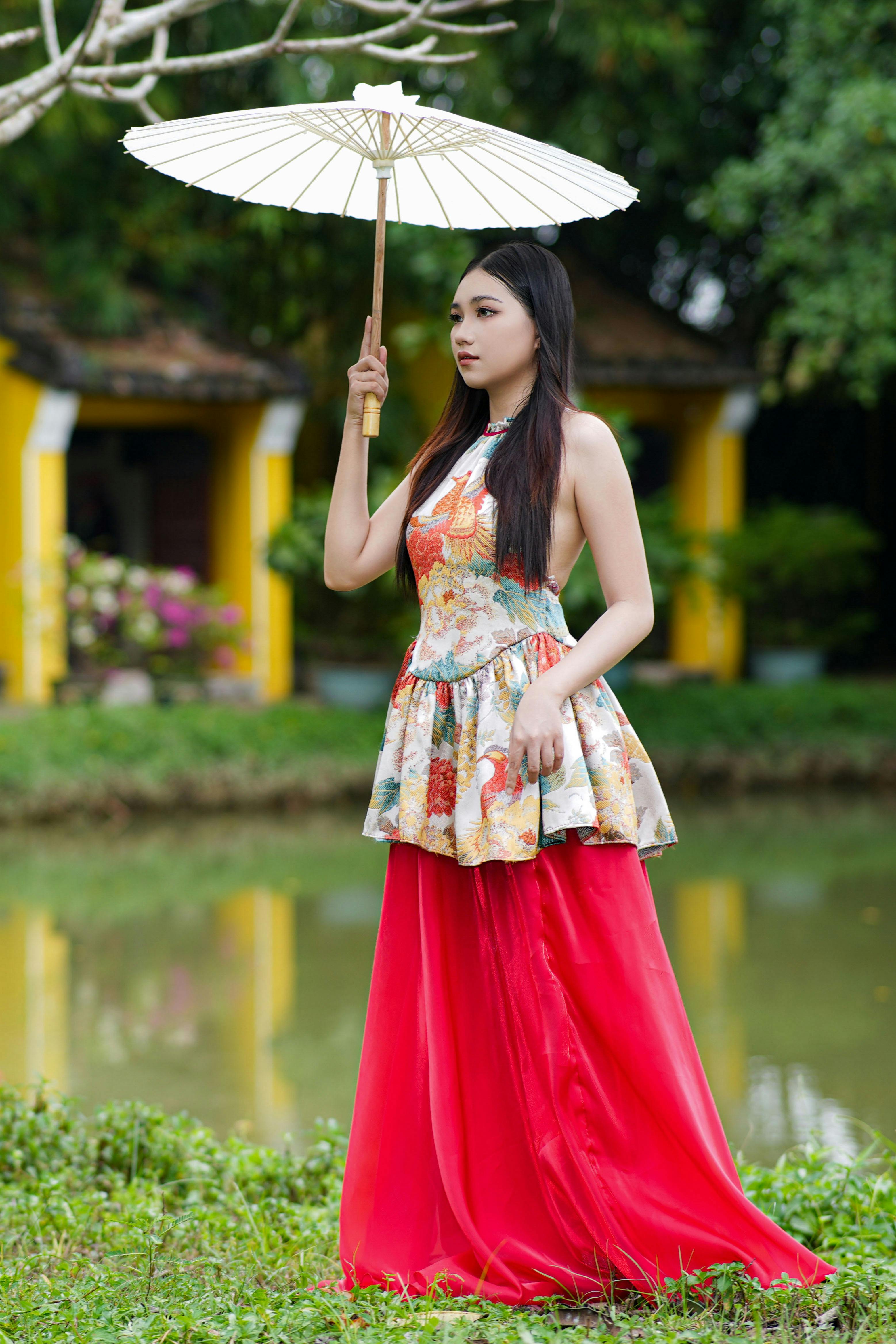 Elegant Woman in Traditional Asian Attire by Pond · Free Stock Photo
