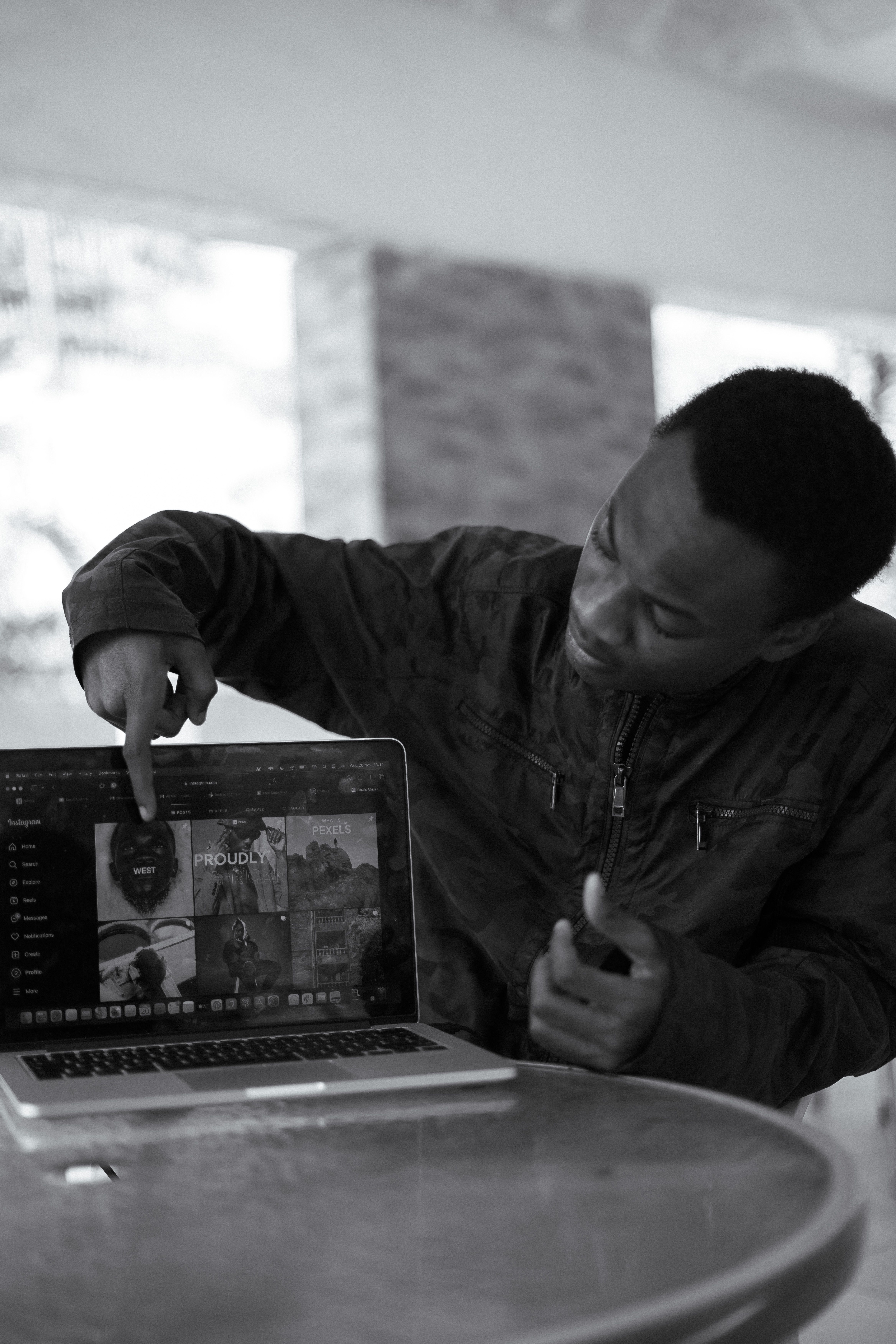 Man pointing to laptop screen indoors in Nigeria · Free Stock Photo