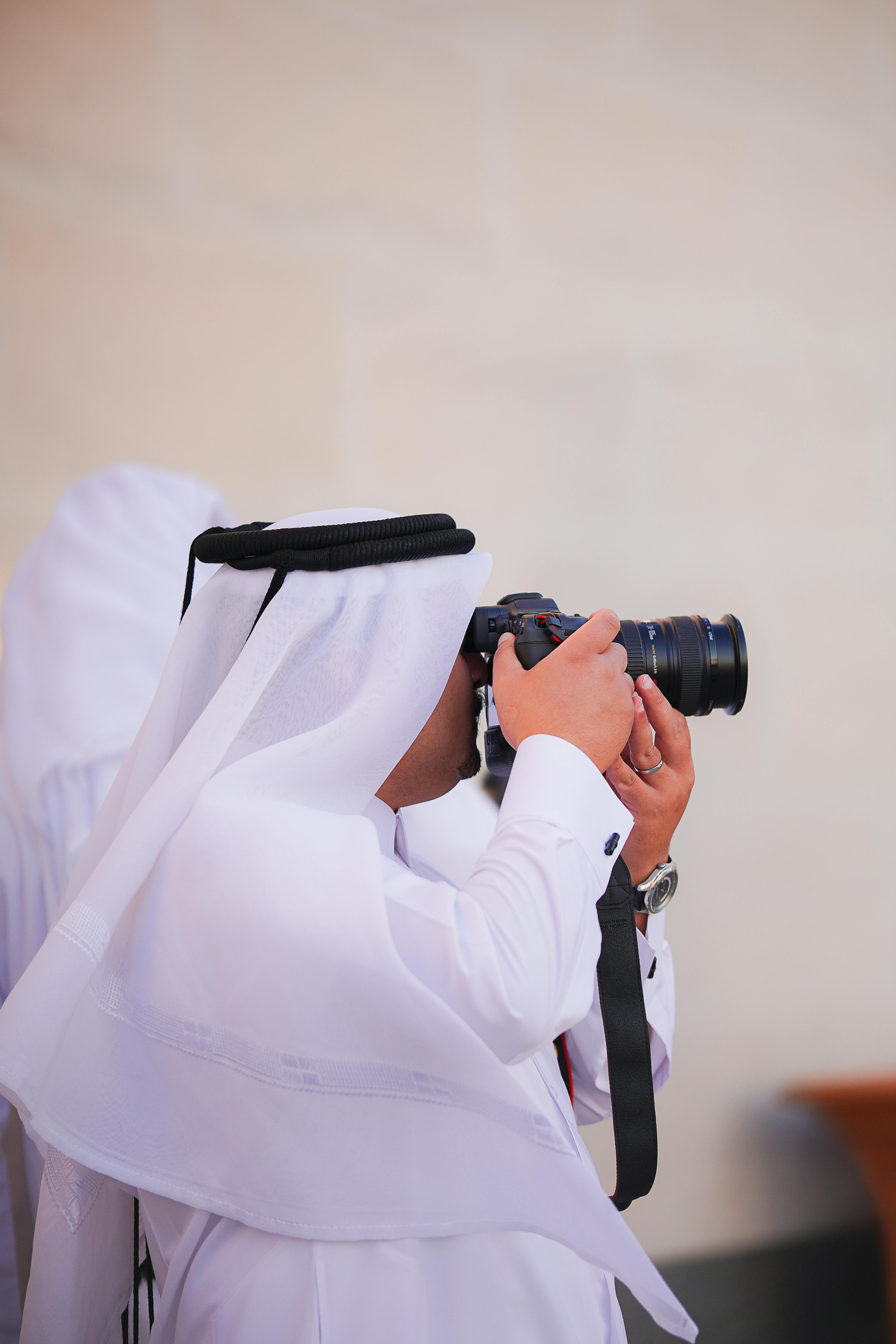 Traditional Qatari Man Photographing Outdoors · Free Stock Photo