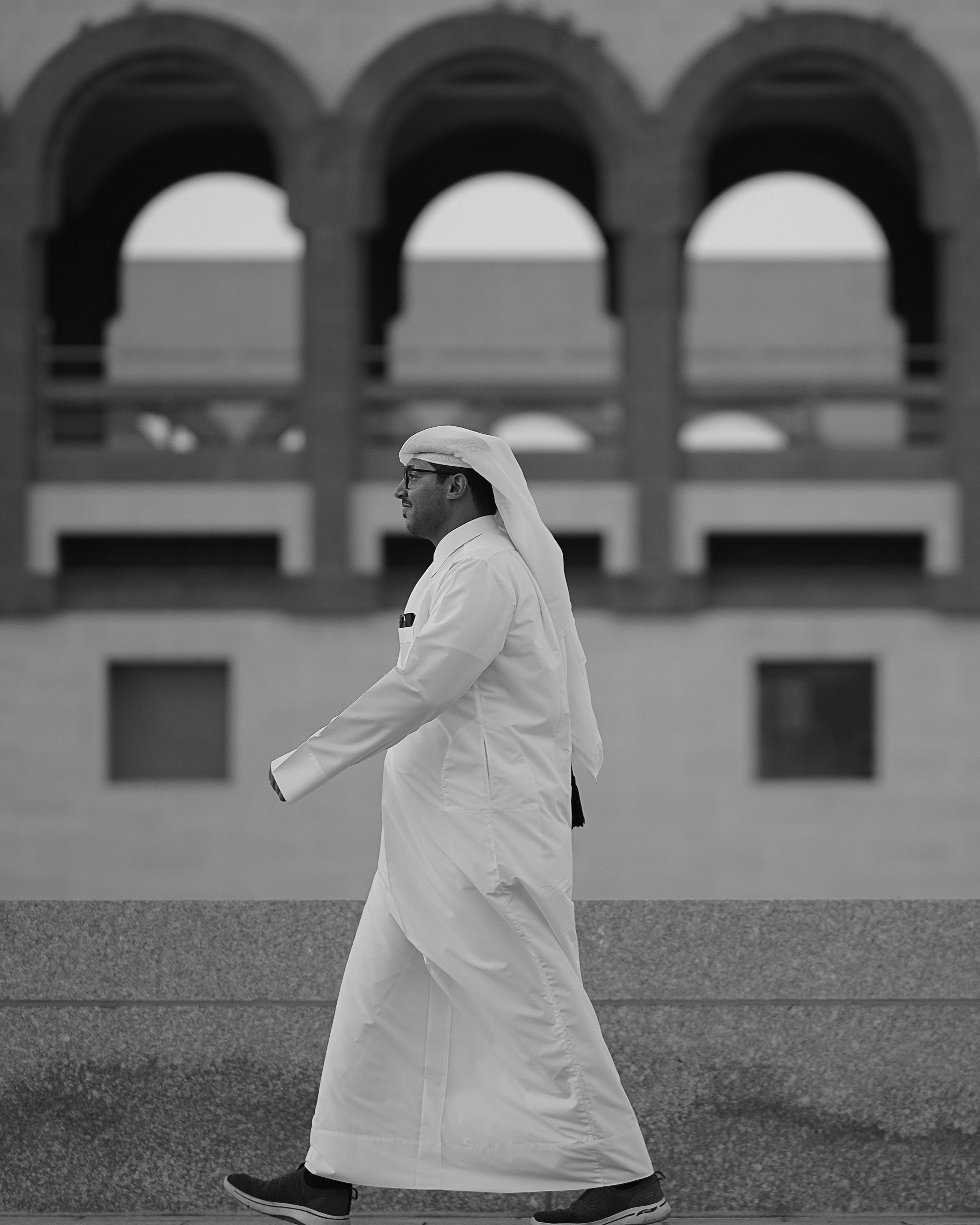 Middle Eastern Man Walking by Doha Architecture · Free Stock Photo