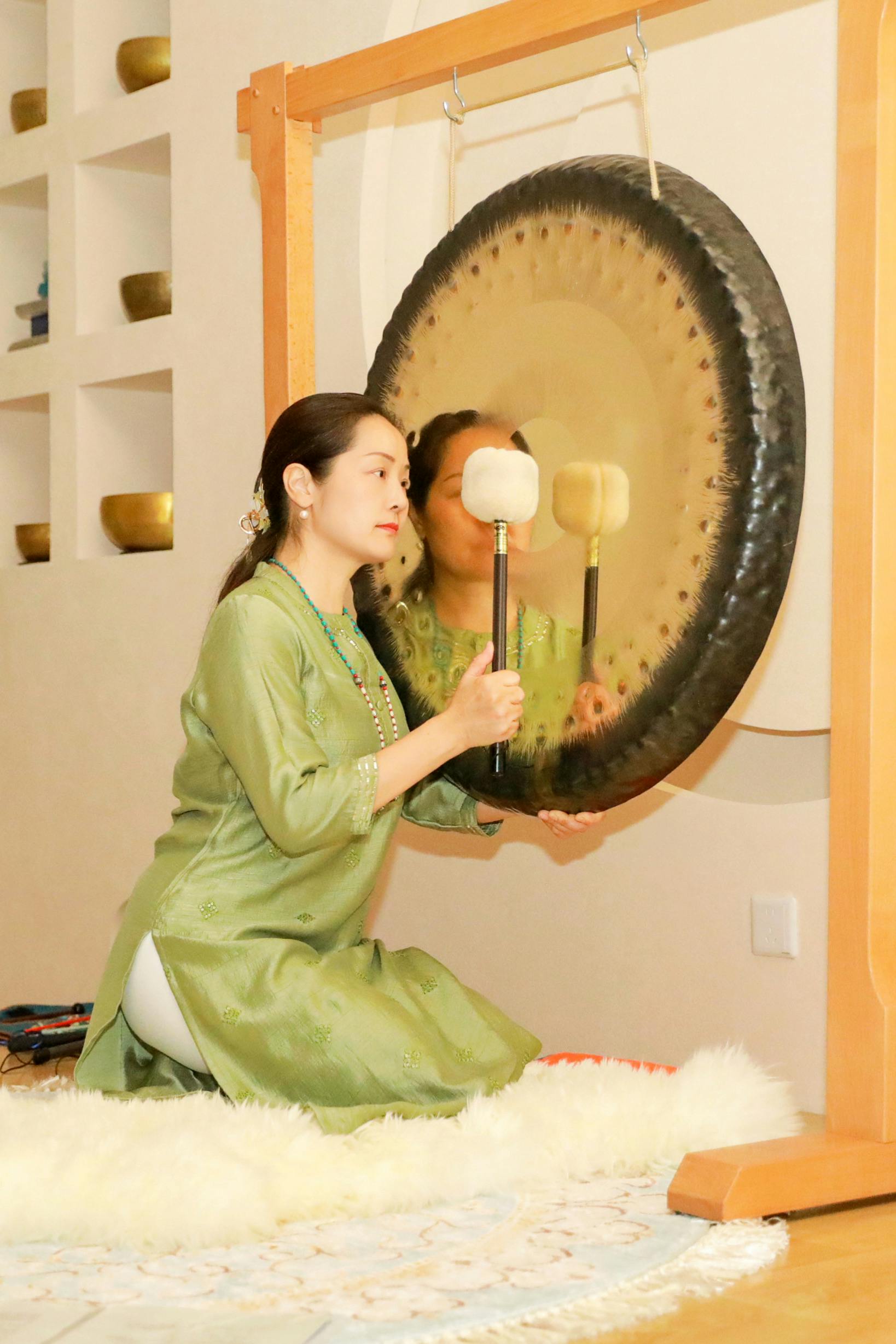 Woman Playing Gong for Sound Therapy Indoors · Free Stock Photo