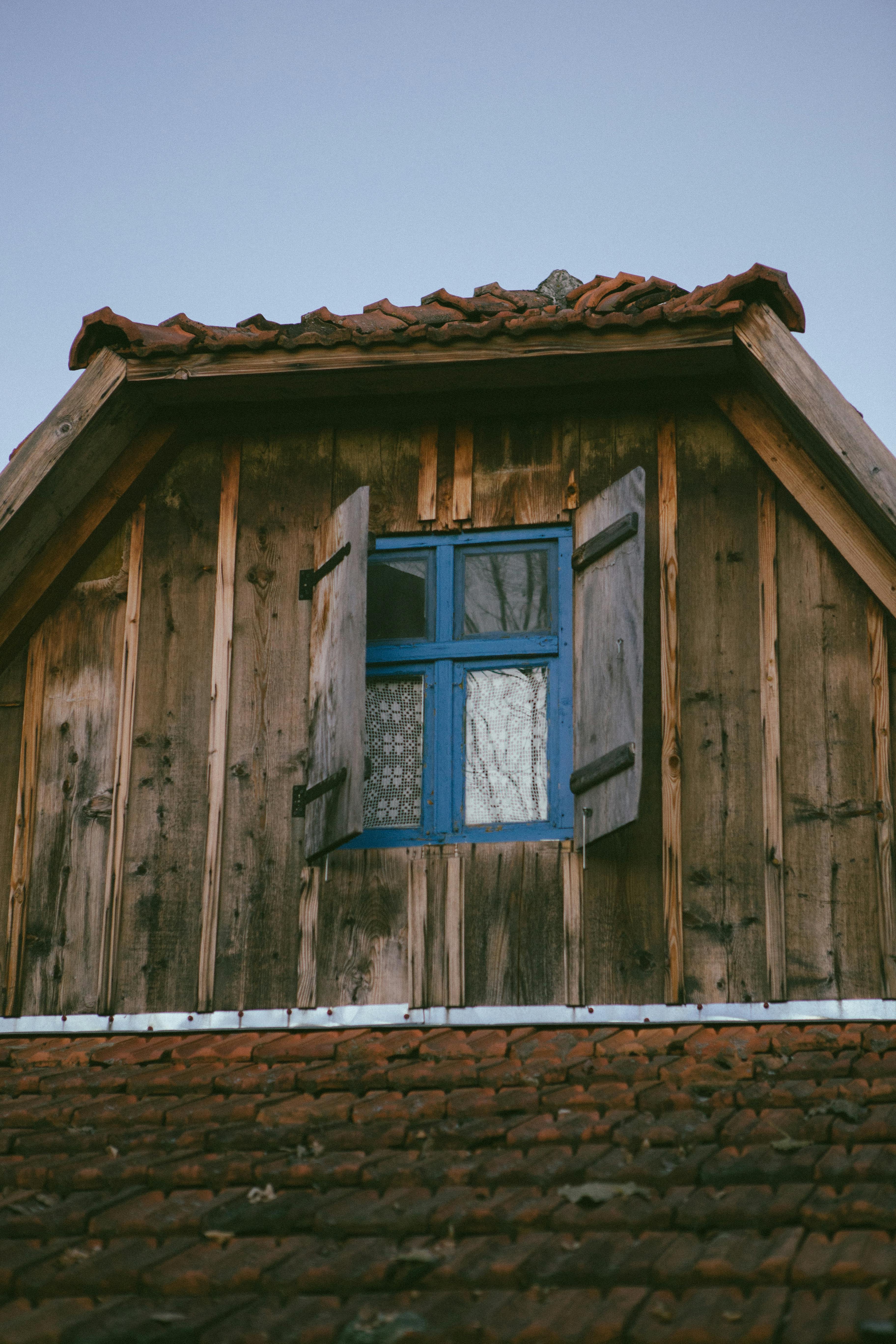 Rustic Wooden Cottage with Blue Shuttered Window · Free Stock Photo