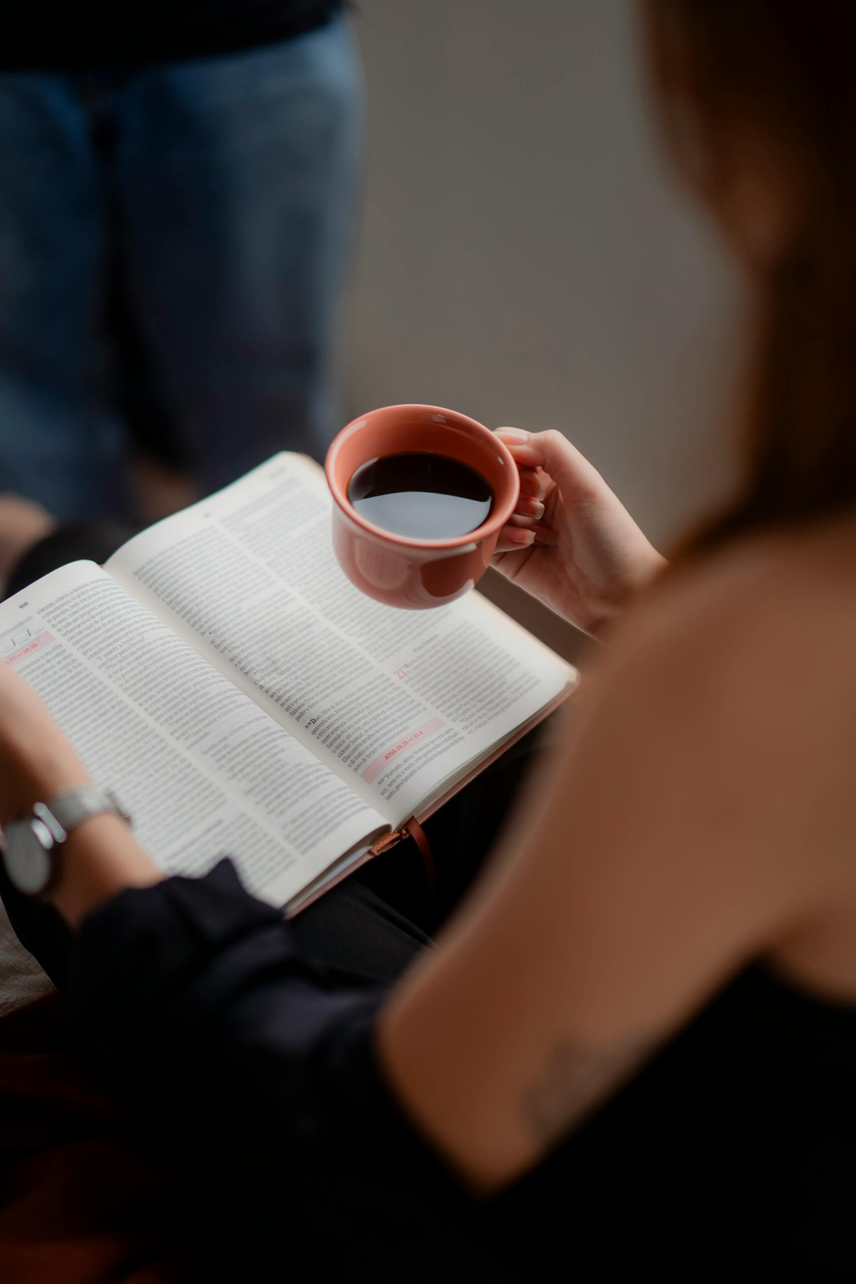 Woman Reading with Coffee in Hand Close-up · Free Stock Photo