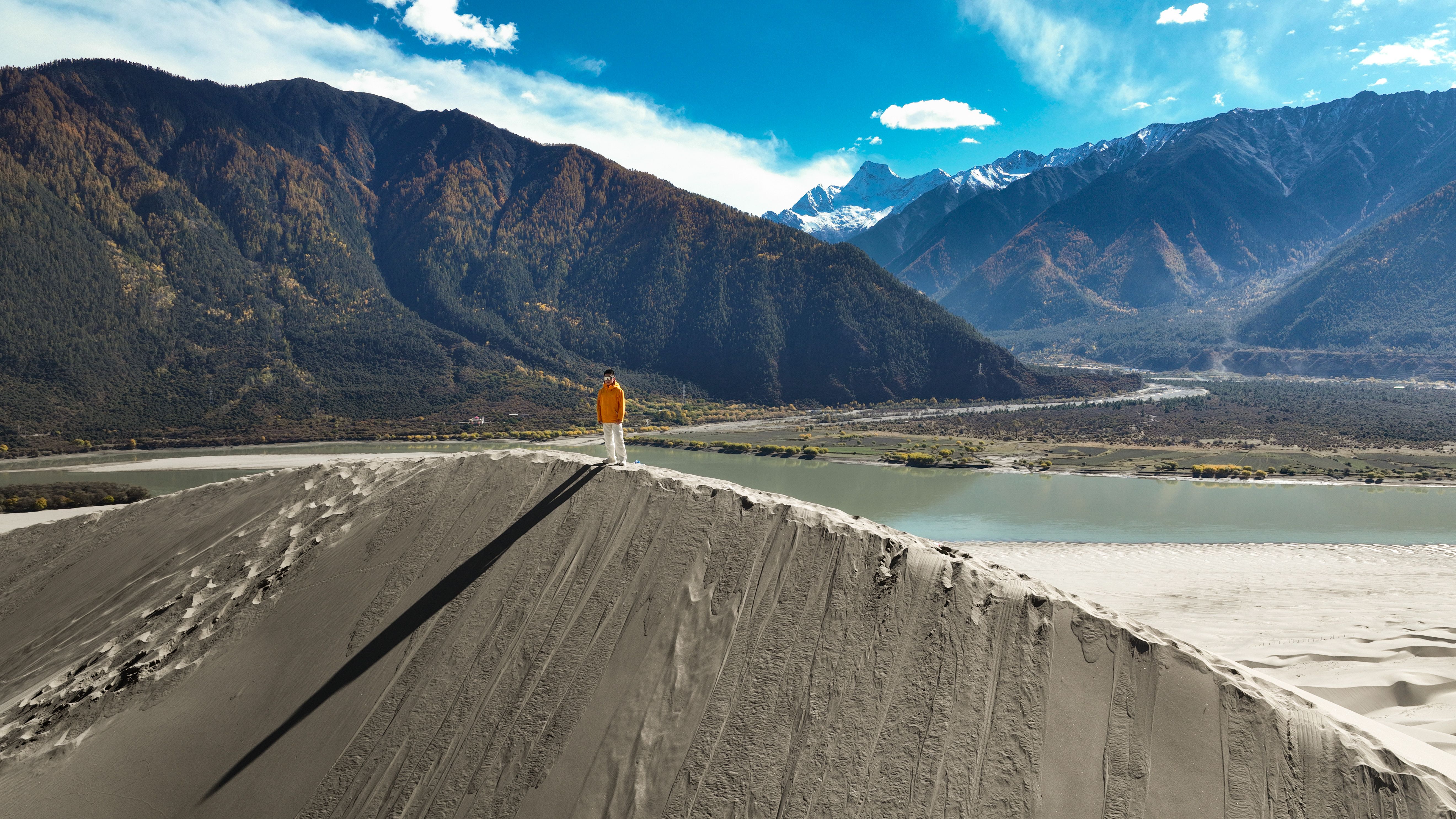 Lone Hiker on Sandy Ridge Overlooking River Valley · Free Stock Photo