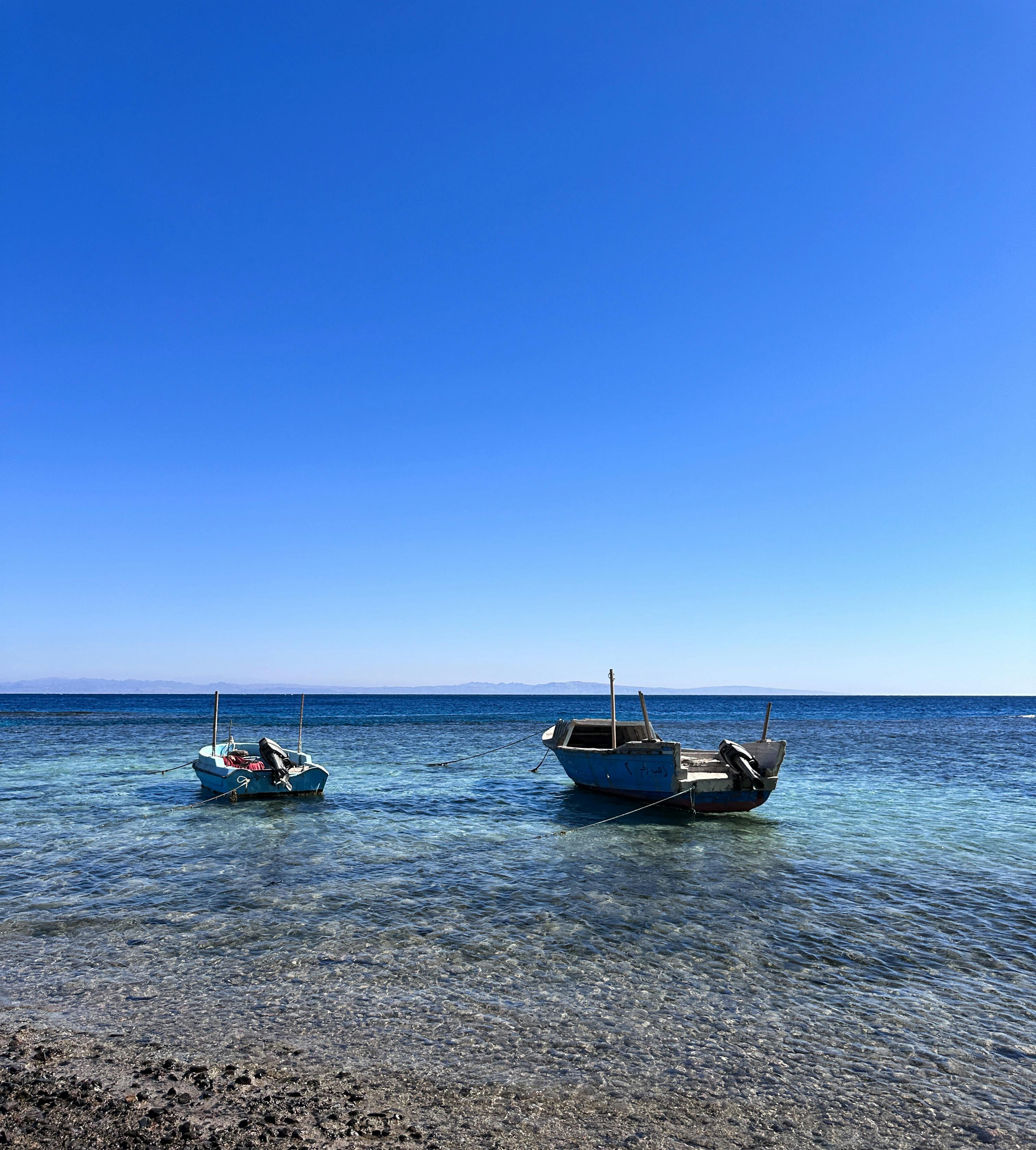 Tranquil Boats Floating on a Clear Blue Sea · Free Stock Photo