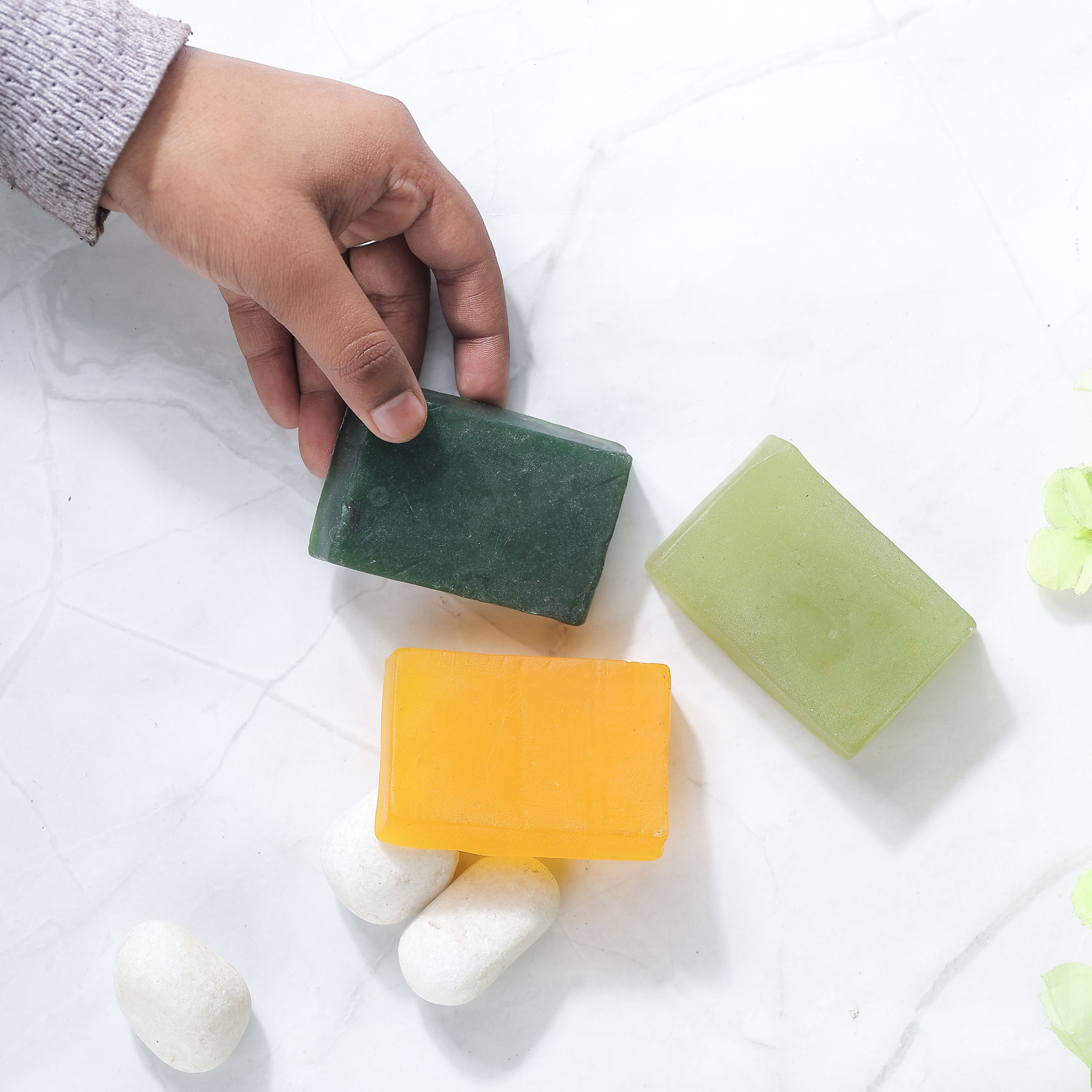 Hand Picking Natural Soap Bars on Marble Surface · Free Stock Photo