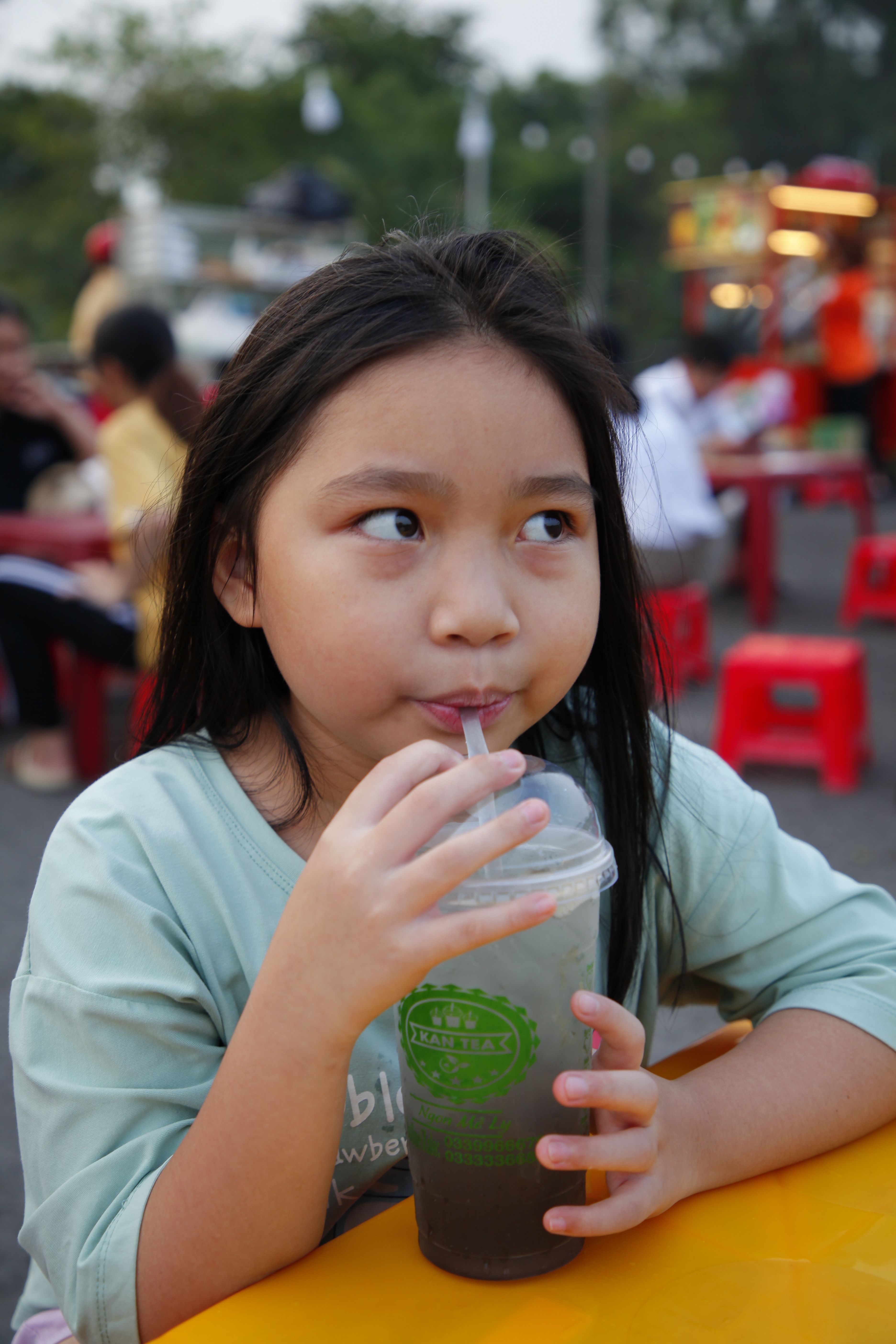 Young Girl Enjoying a Refreshing Drink Outdoors · Free Stock Photo