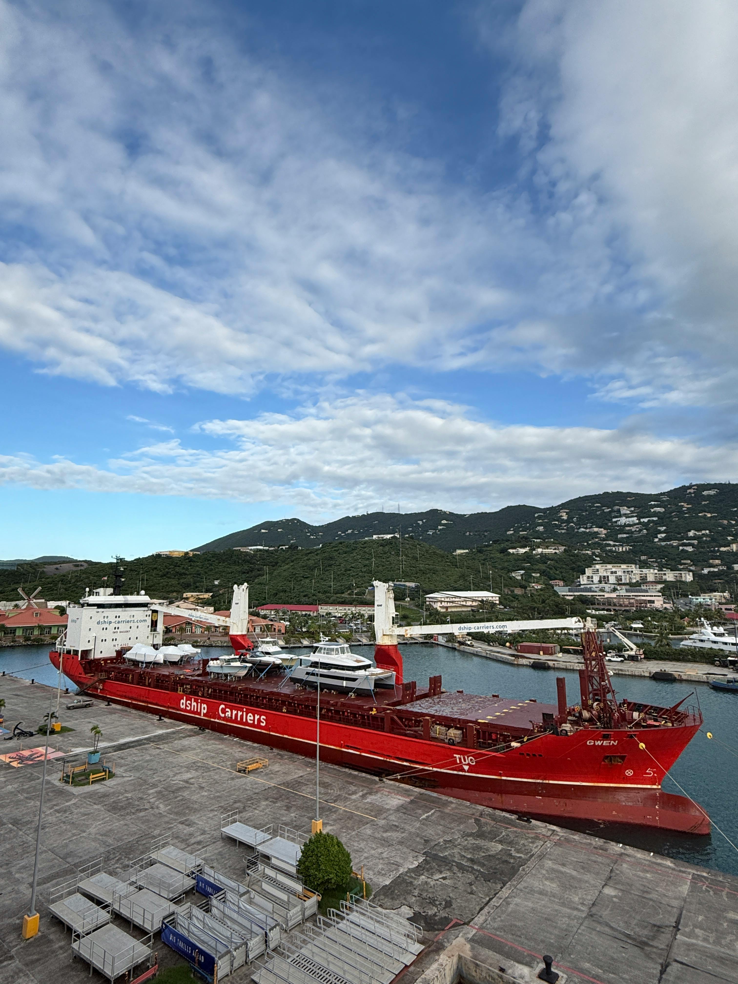 Red Cargo Ship Docked in Scenic Harbor · Free Stock Photo