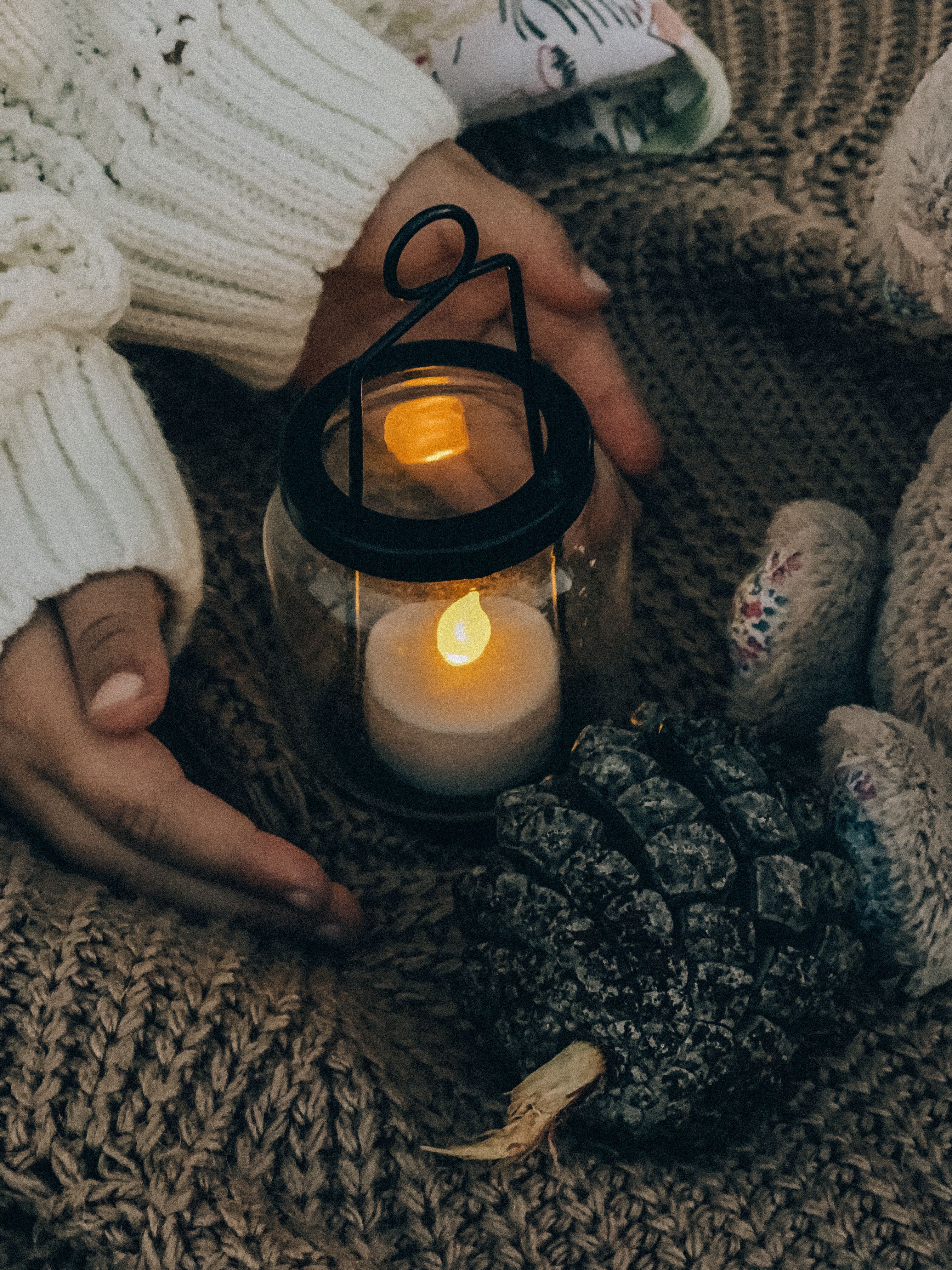 Cozy Winter Scene with Candle and Pinecone · Free Stock Photo