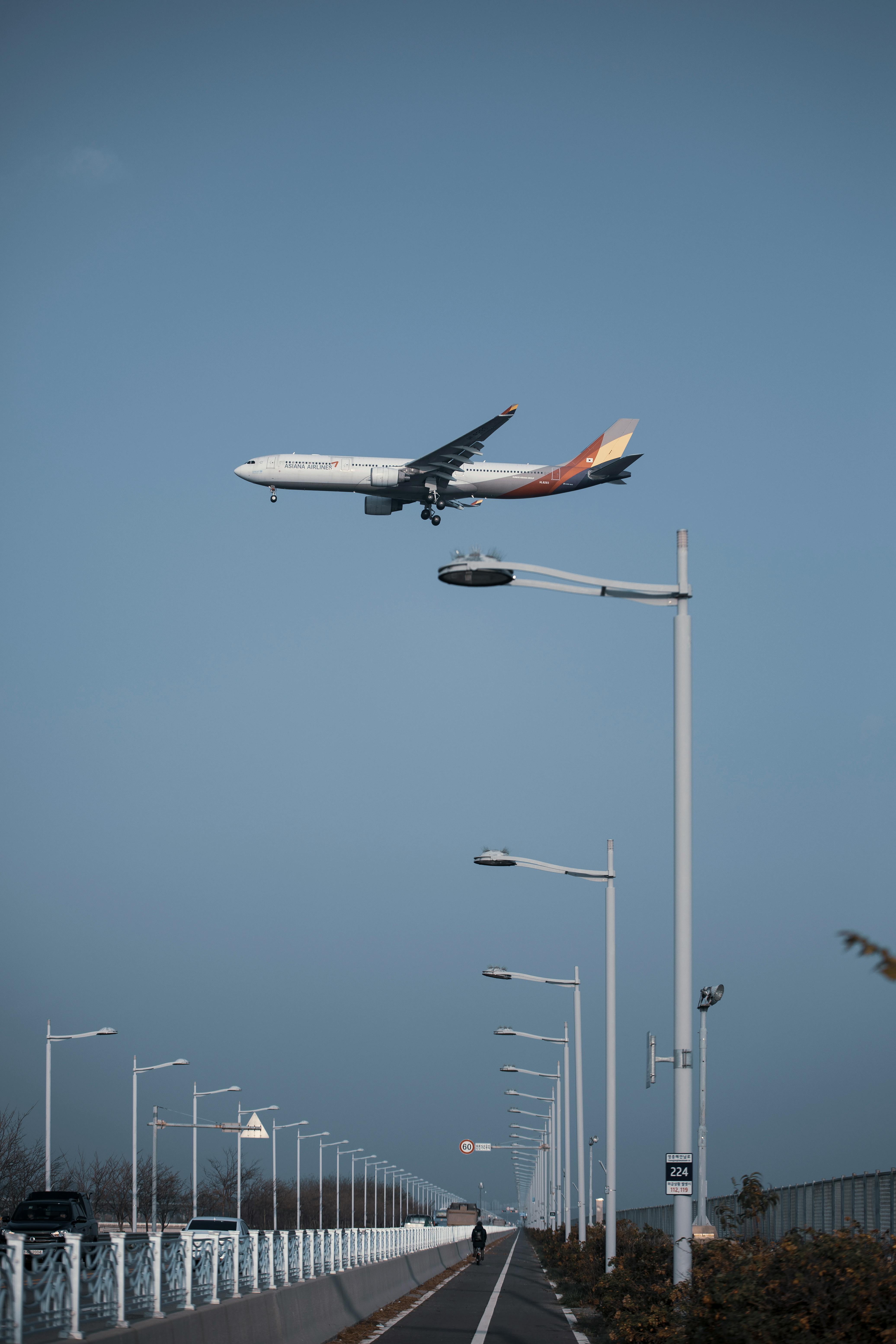 Airplane Landing Over Urban Pathway · Free Stock Photo